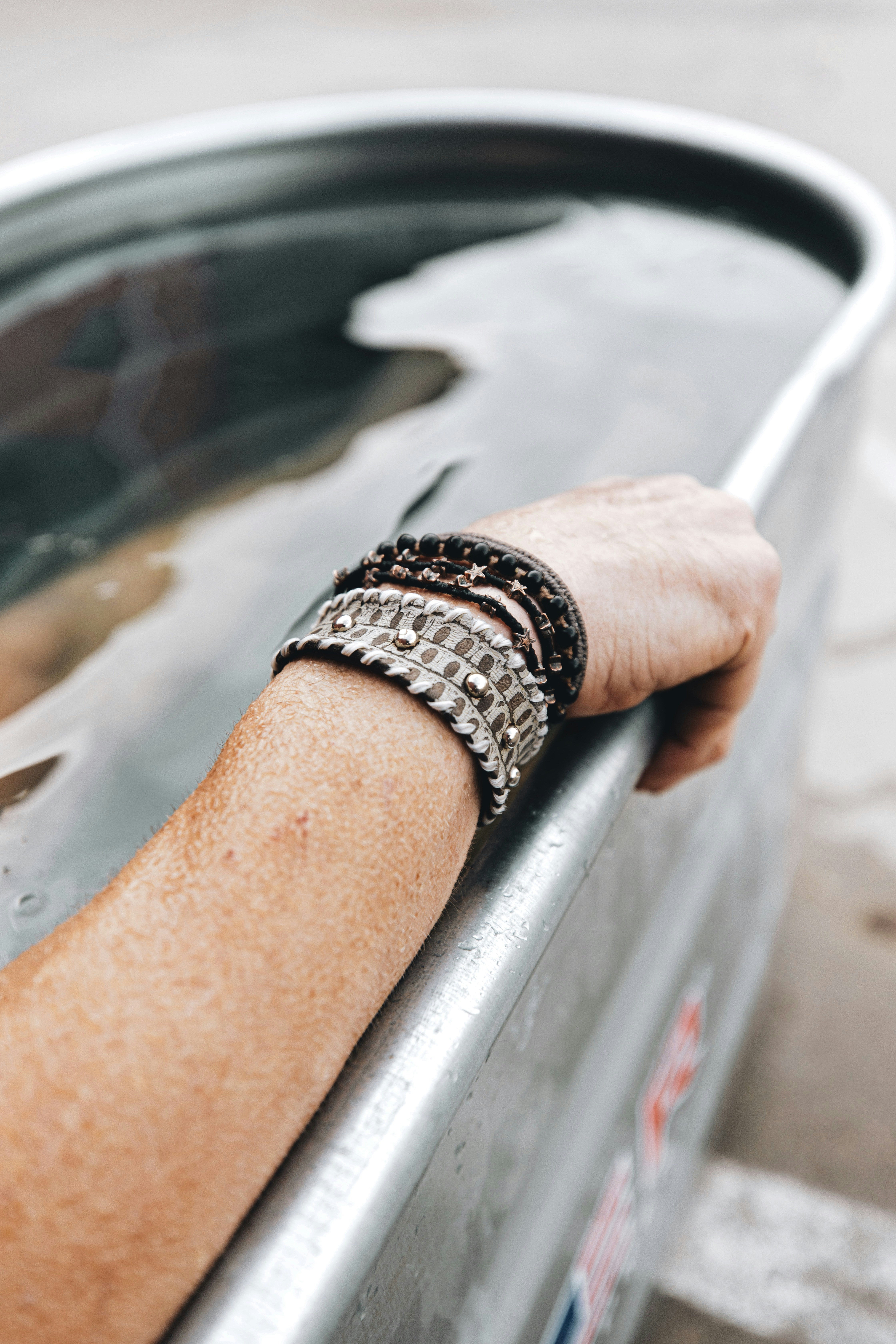 Wristful Grip: Leather Bands Resting on a Weathered Tub Edge