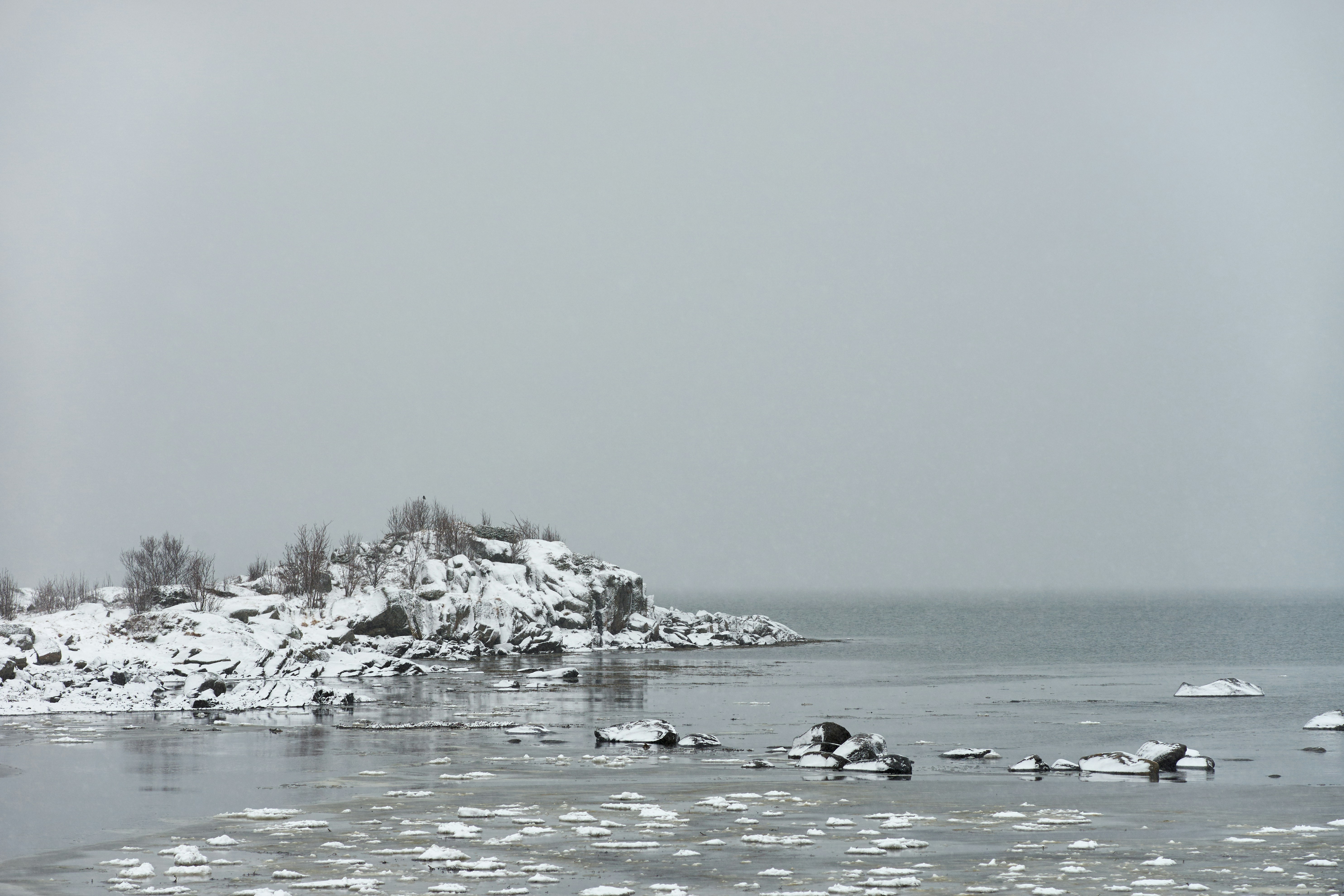 Snowbound Promontory Against a Calm, Overcast Sea