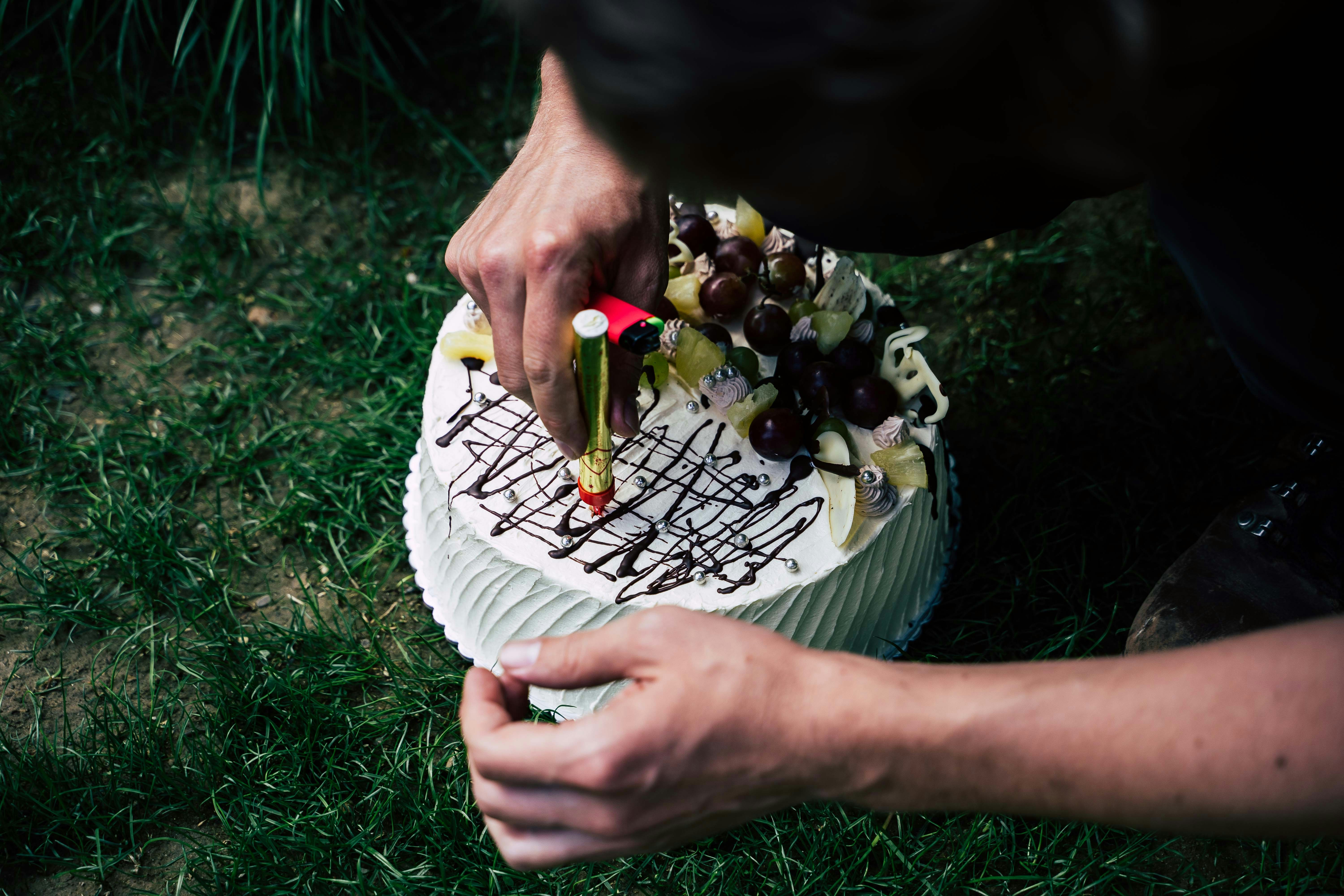 Hands on the Slice: A Birthday Candle Sparks a Sweet Moment