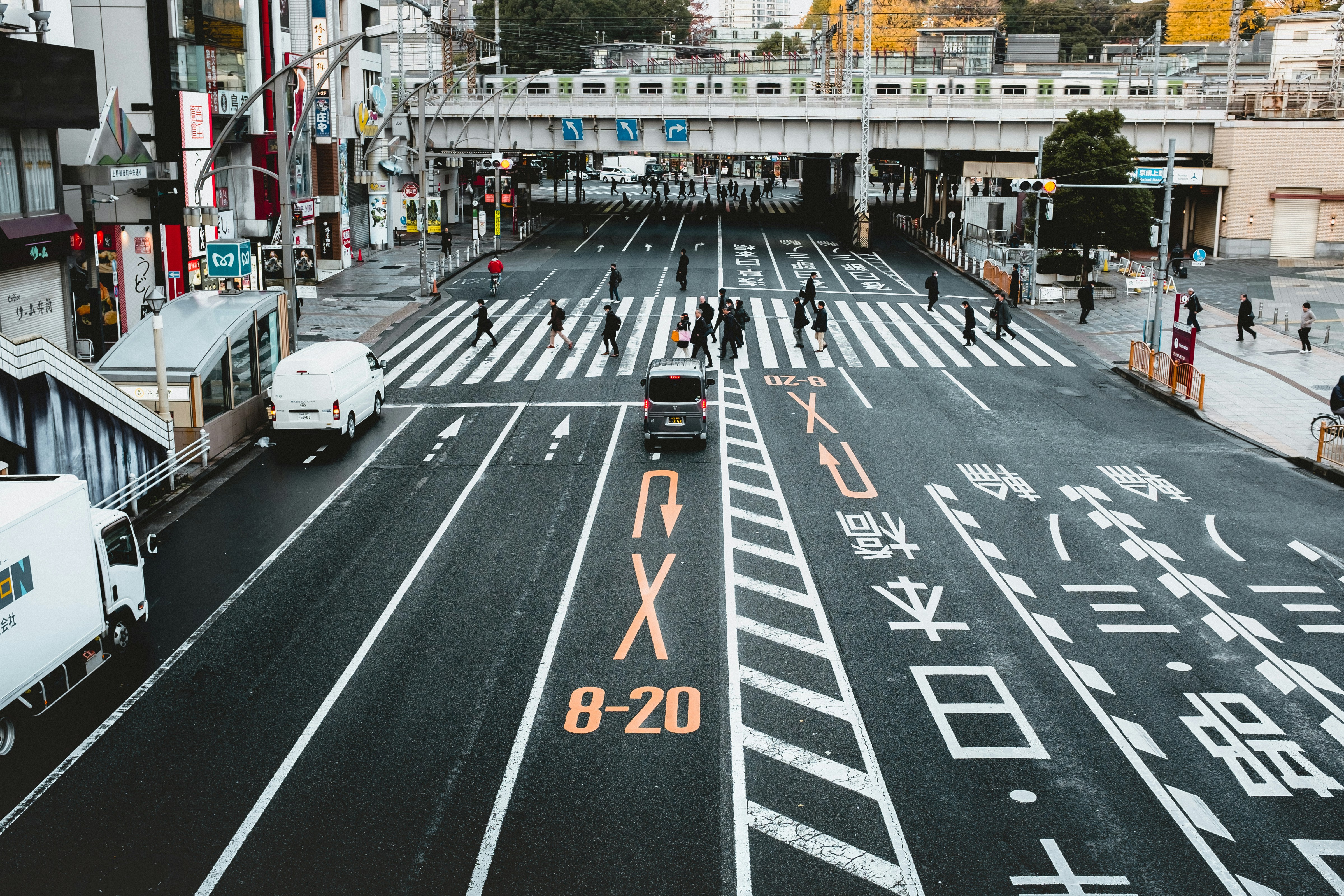 Aerial view of a bustling city intersection with distinctive road markings and vehicles navigating multiple lanes.