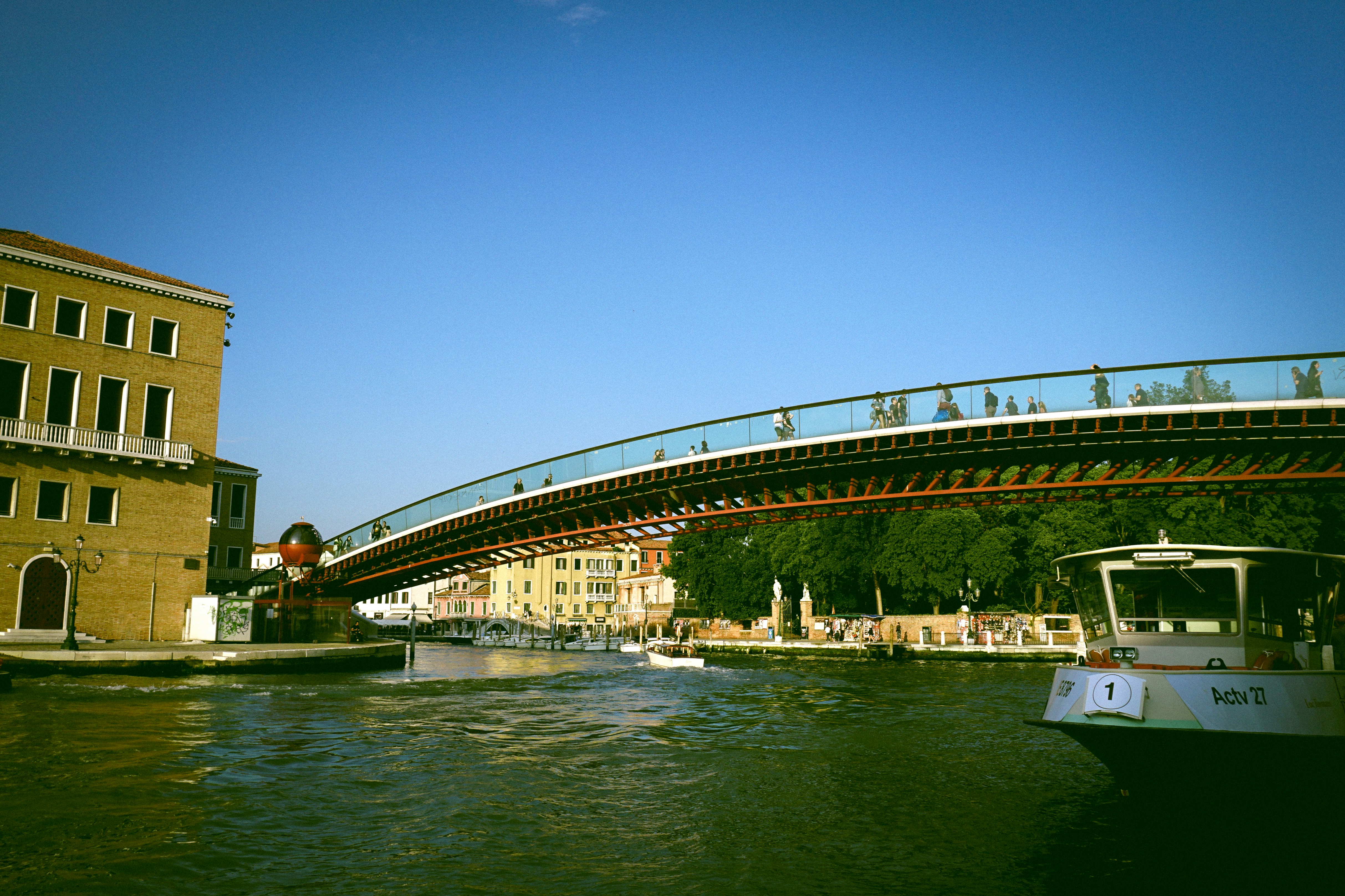 Curve of Light: A Pedestrian Bridge Arcing Over a Sunlit Canal