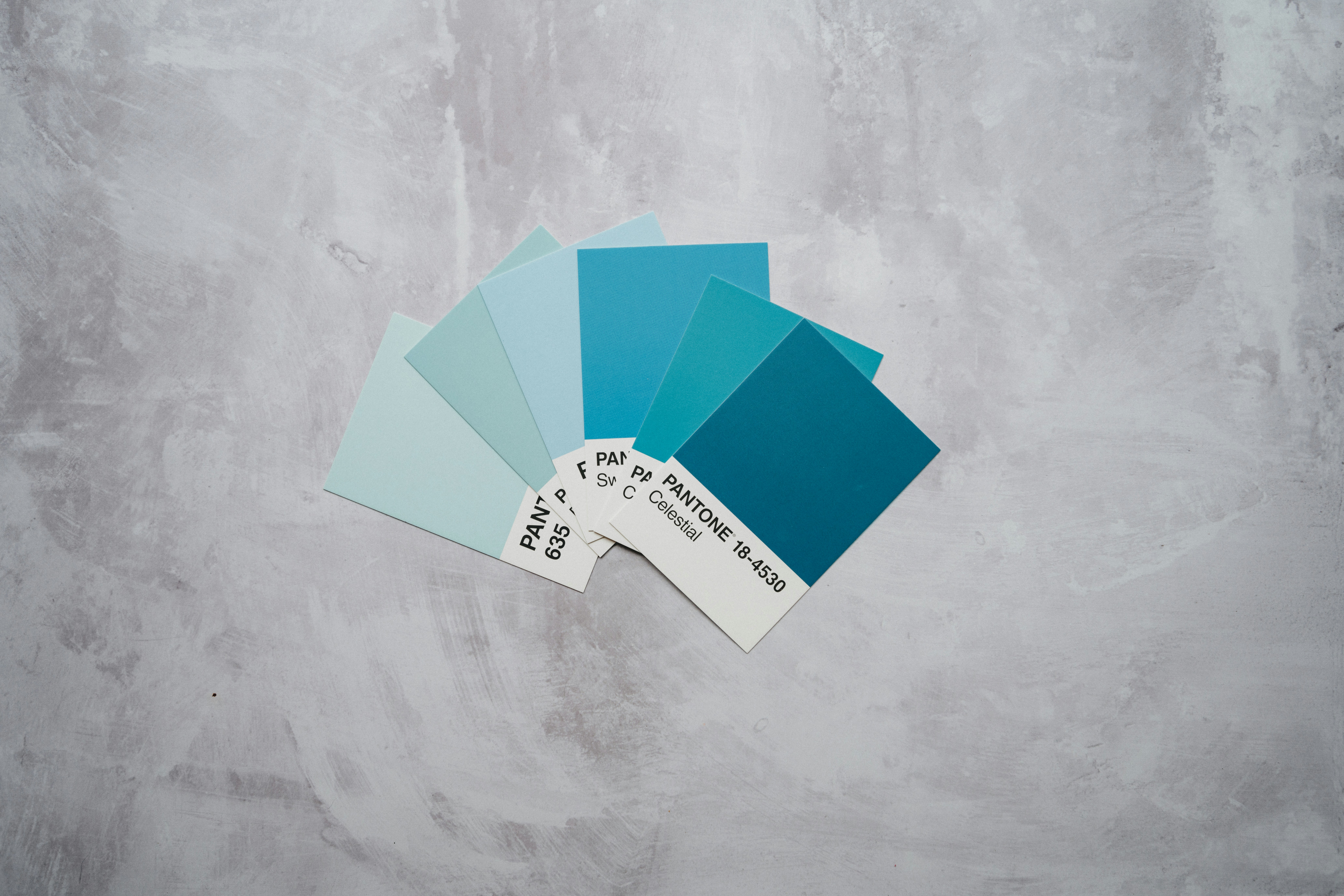 Palette of Quiet Blues: A Fan Deck Fanned Across a Concrete Surface