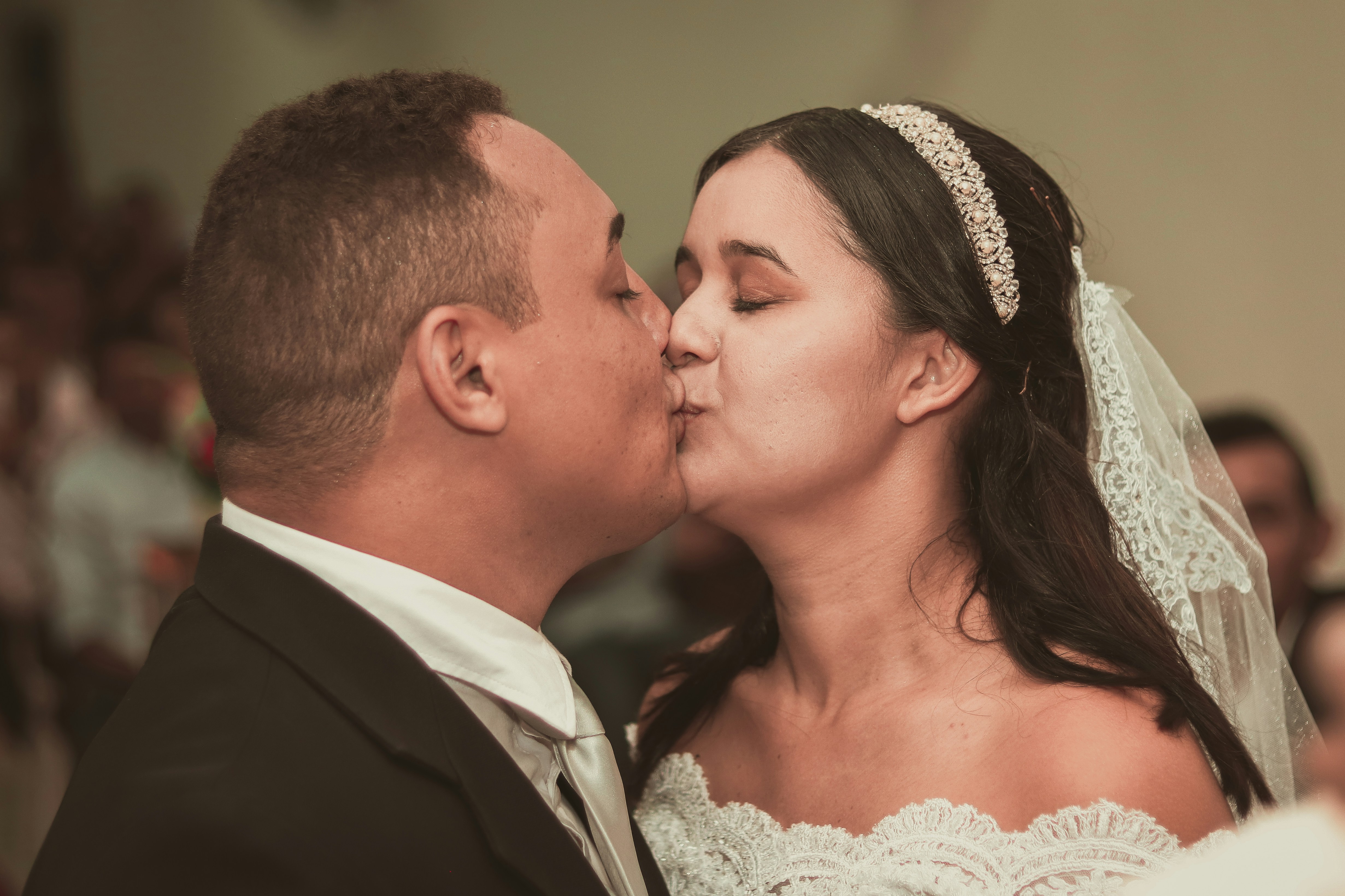 Bride and groom share a gentle kiss during their wedding ceremony.