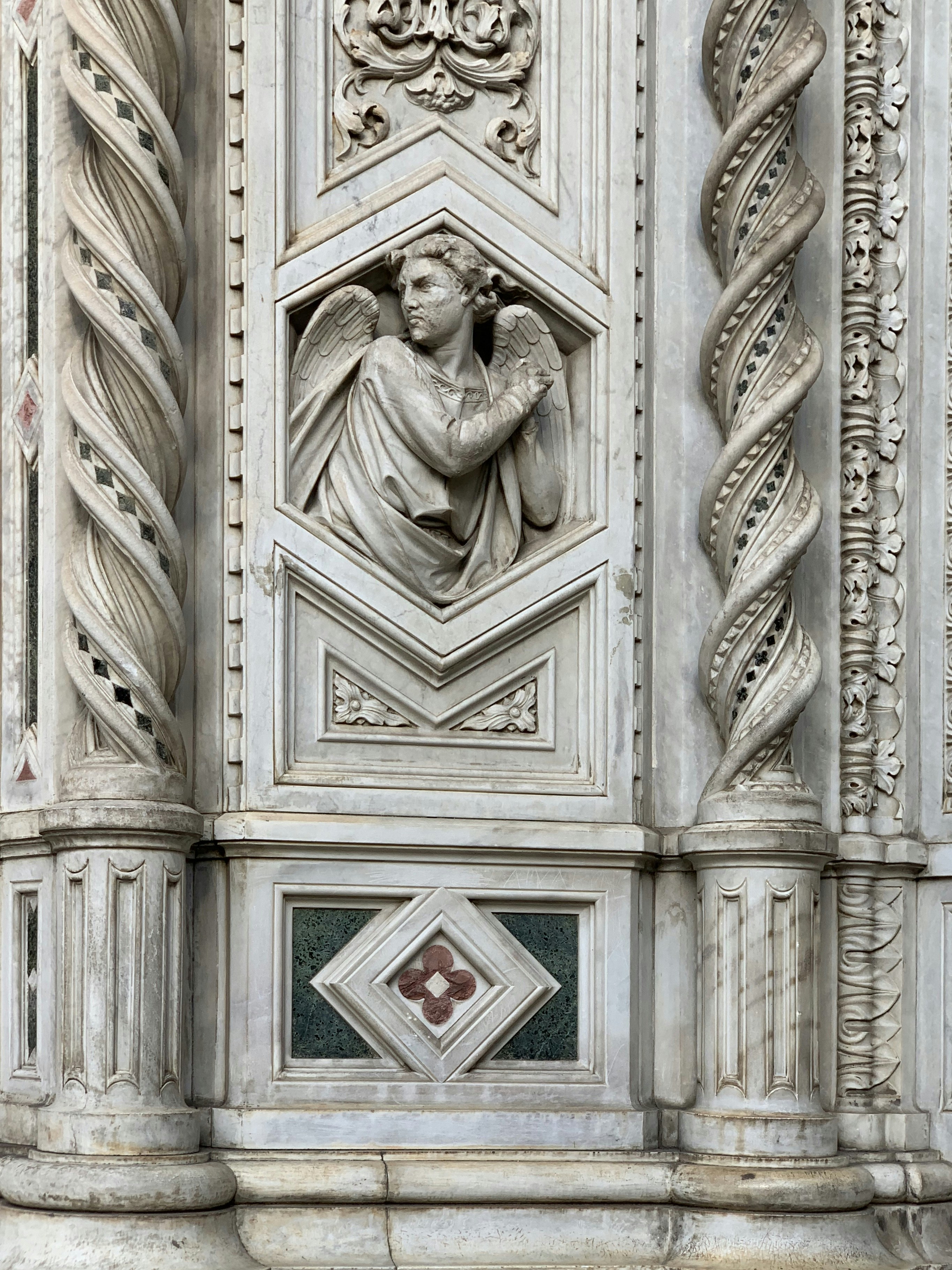 Stone Angel Among Spirals: Marble Frieze Framed by Twisted Columns