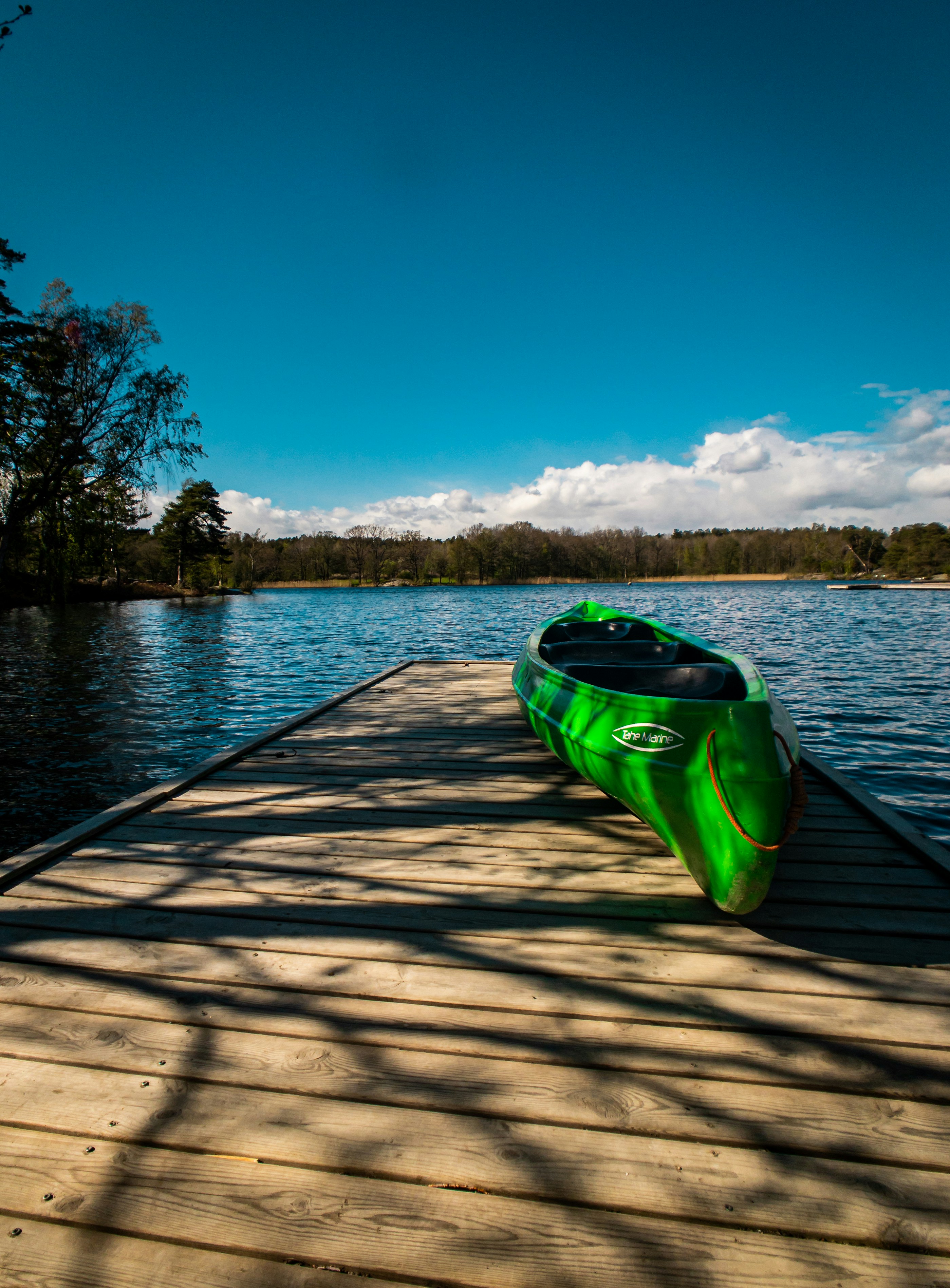 Emerald Kayak at the Dock's Edge on a Quiet Lake