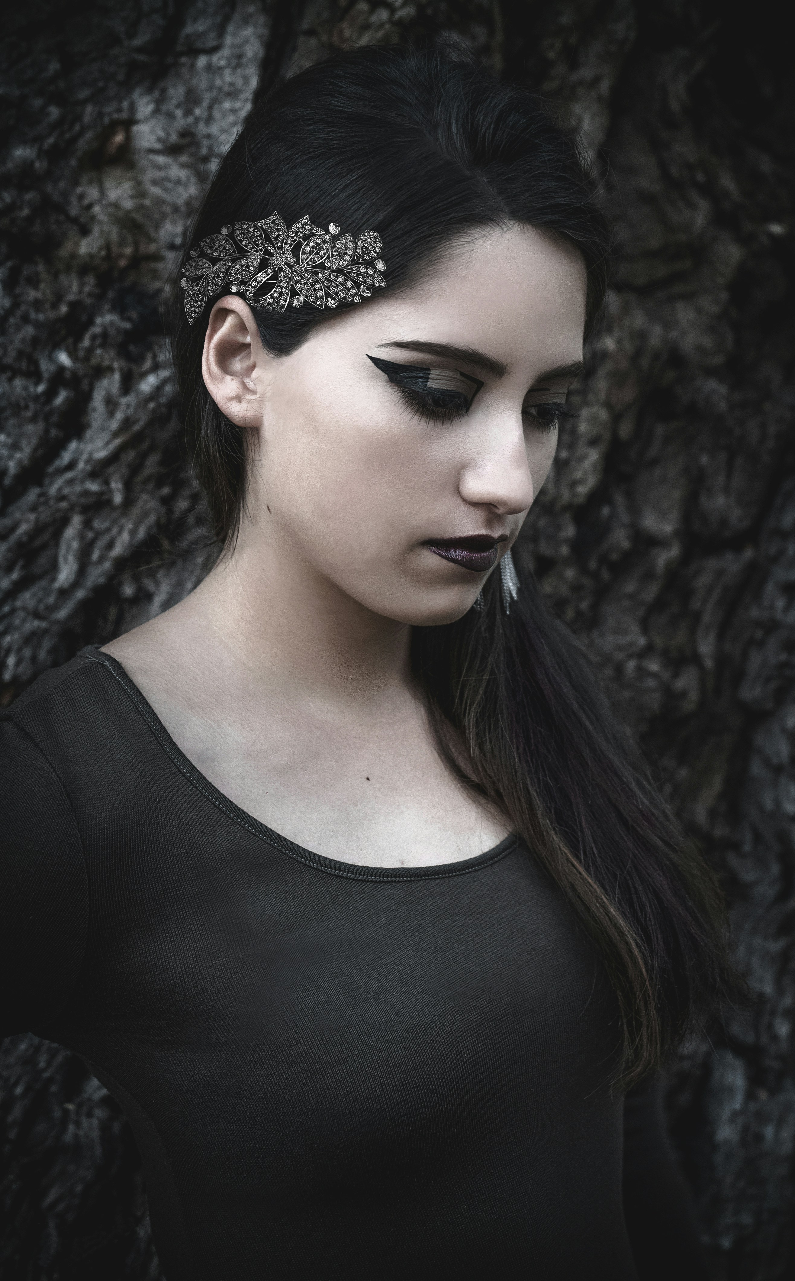 Glimmer in Shadow: Portrait of a Woman with a Jeweled Hairpiece Against Weathered Bark