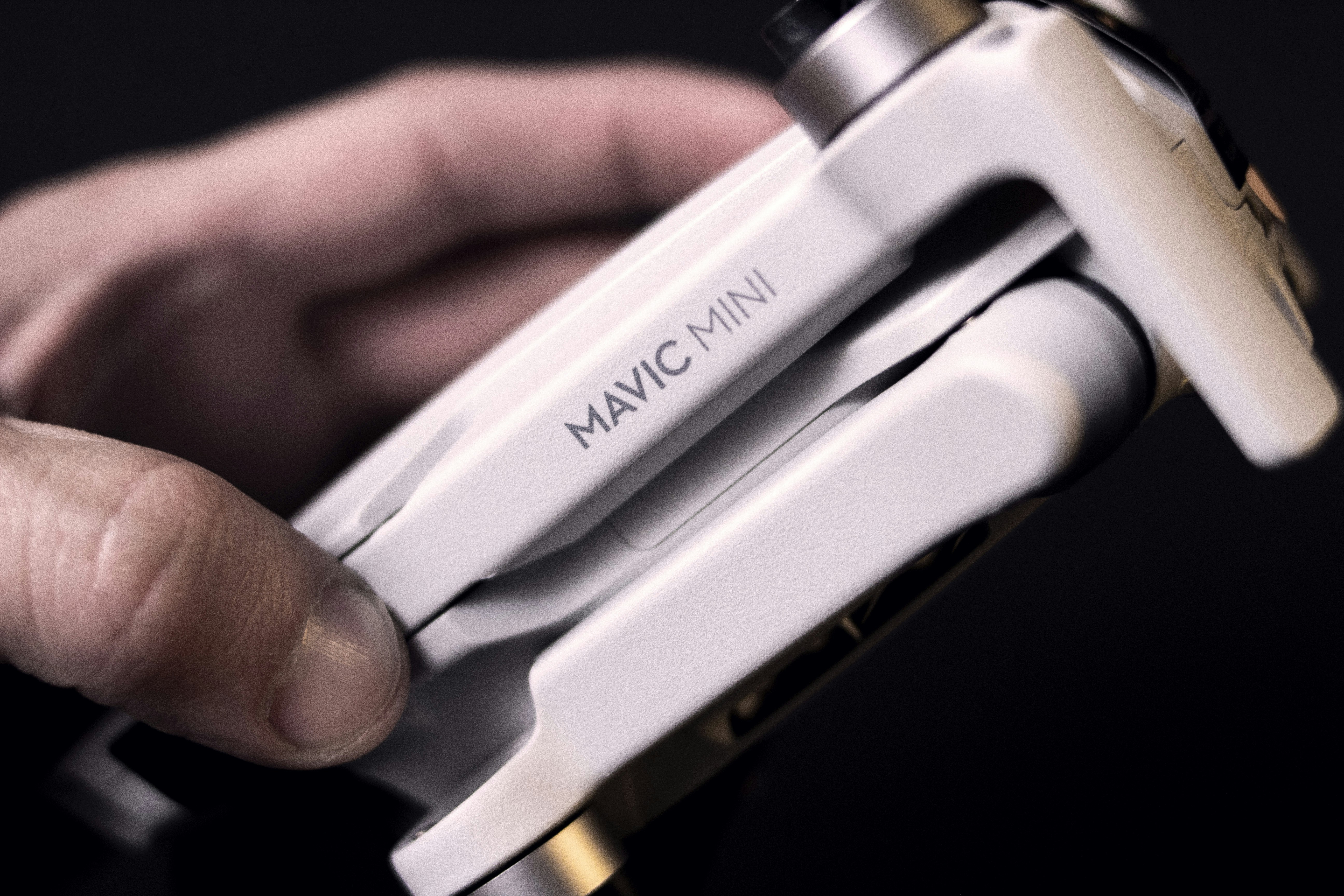 Mid-landing: A close-up of a folded Mavic Mini drone in the palm of a hand
