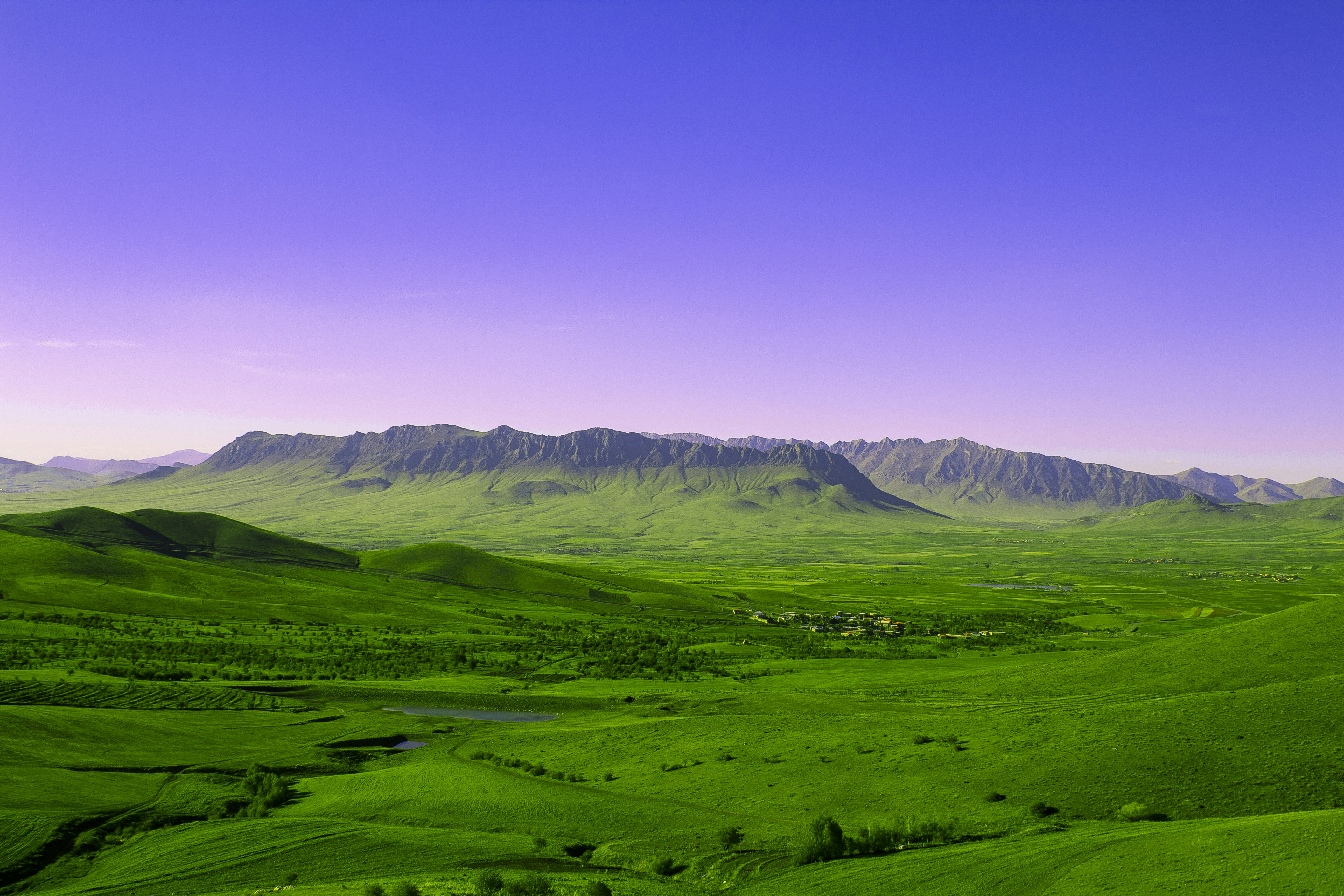 Green grass field near mountain under blue sky during daytime photo ...