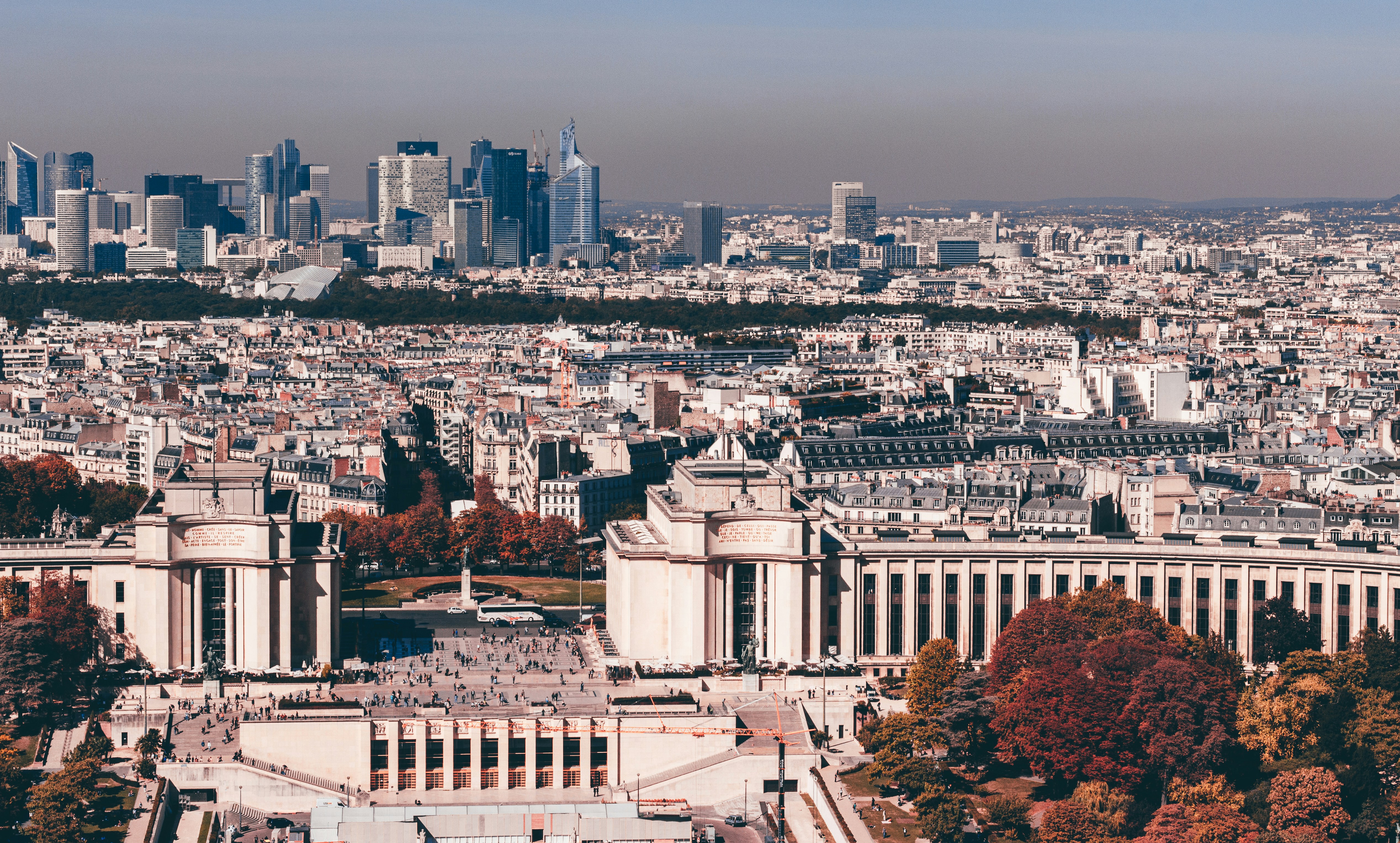 Panoramic view of Paris showcasing the juxtaposition of historical architecture and modern skyscrapers, with the Trocadéro Gardens in the foreground. 