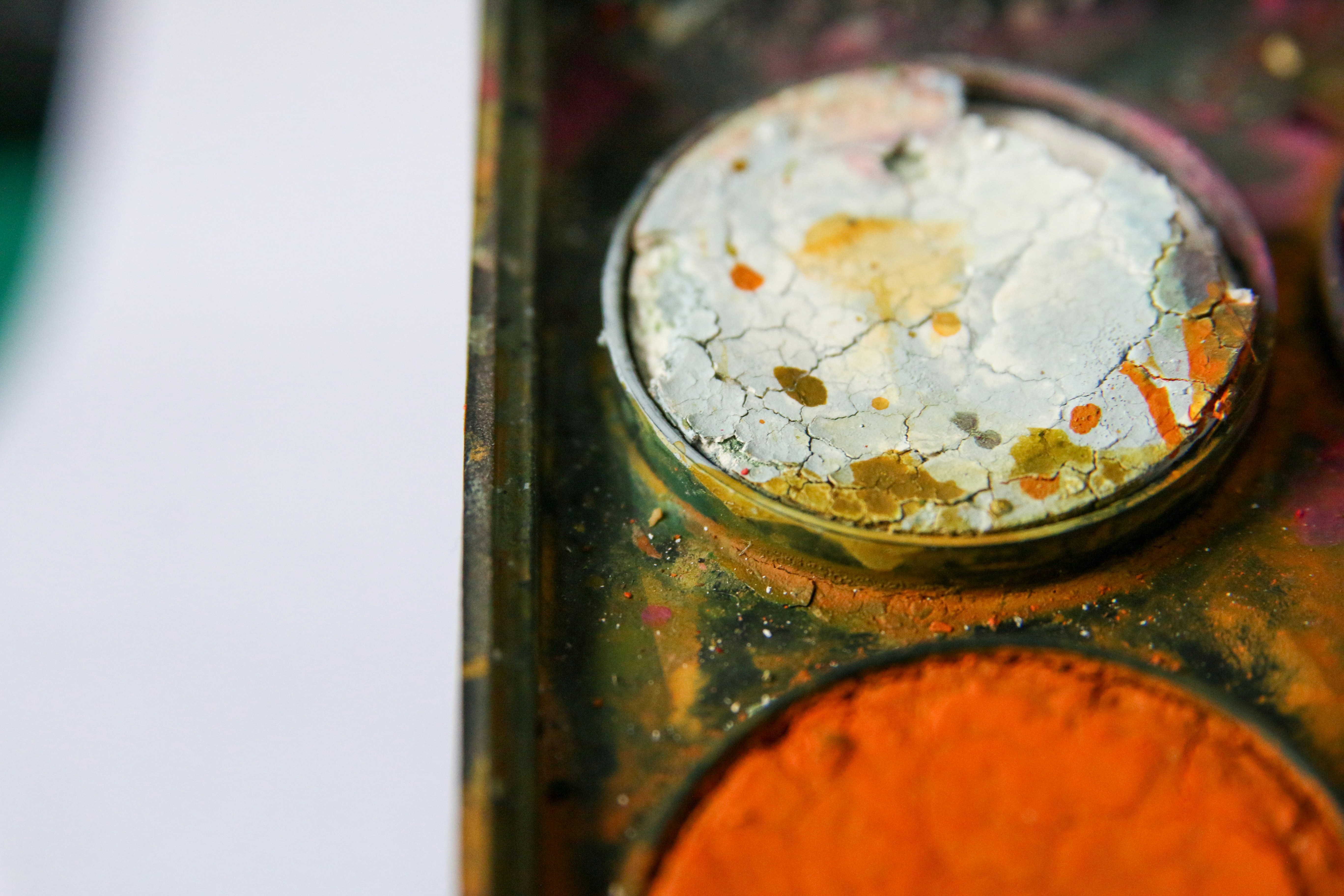 Cracked White Disk on a Weathered Painter's Palette: A Macro Portrait of Texture and Color