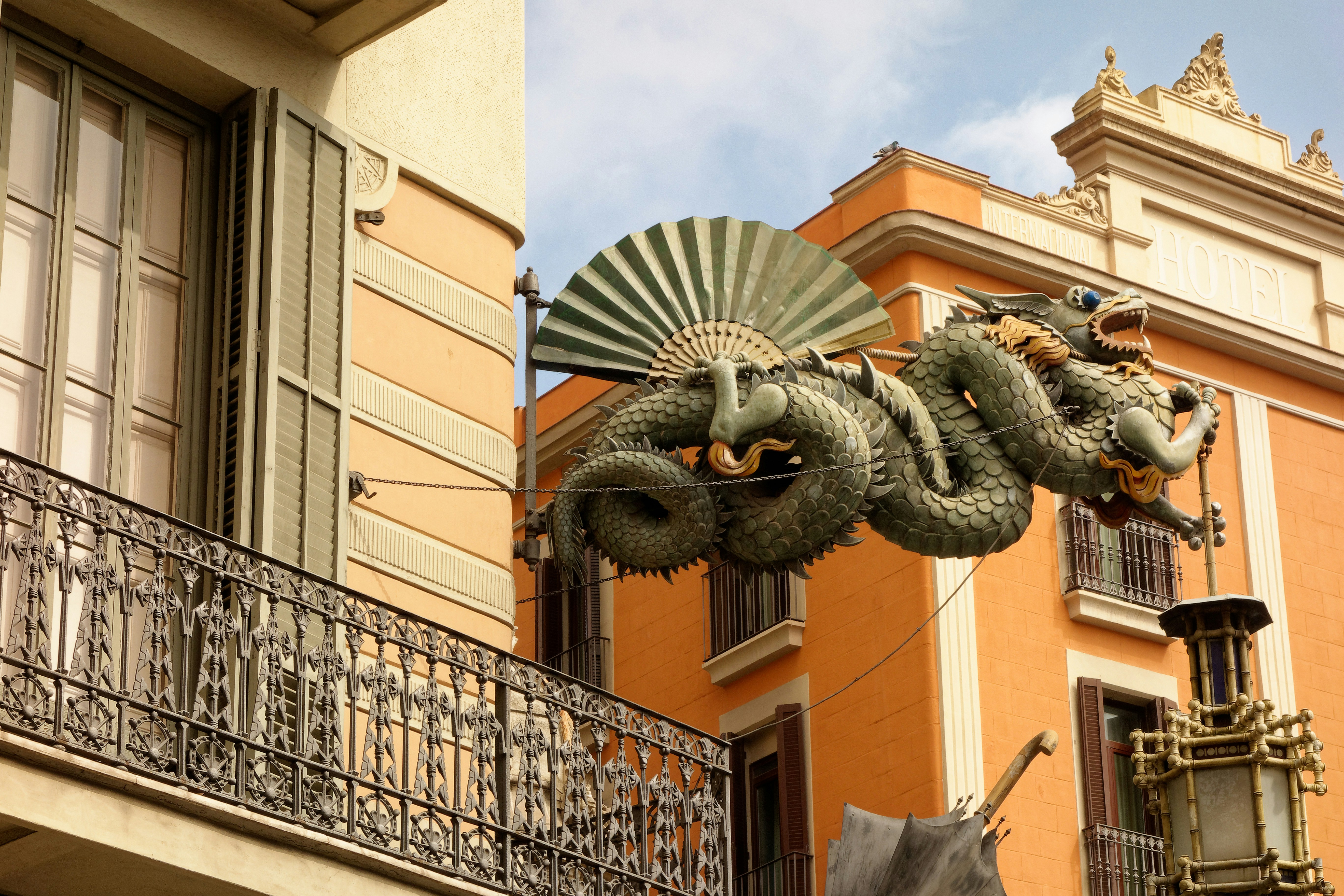 Sunlit Turquoise Dragon Rises Between Ochre Facades