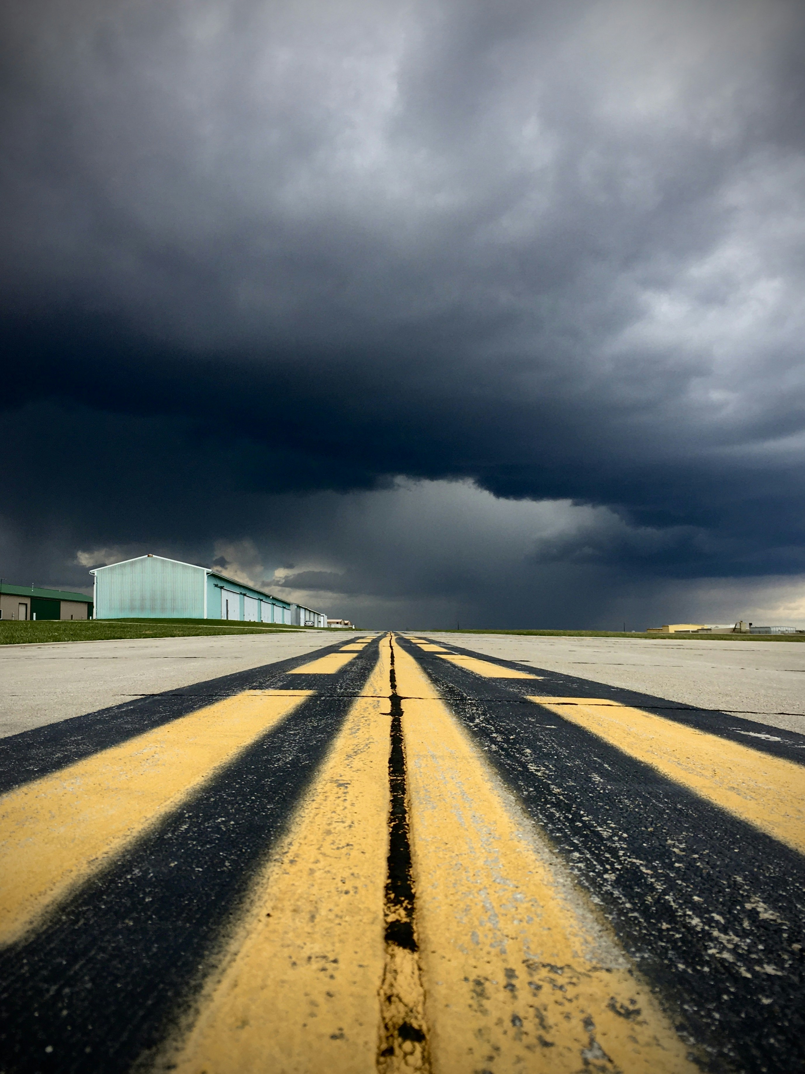 Storm Convergence on the Tarmac: Runway Lines Lead into a Looming Sky