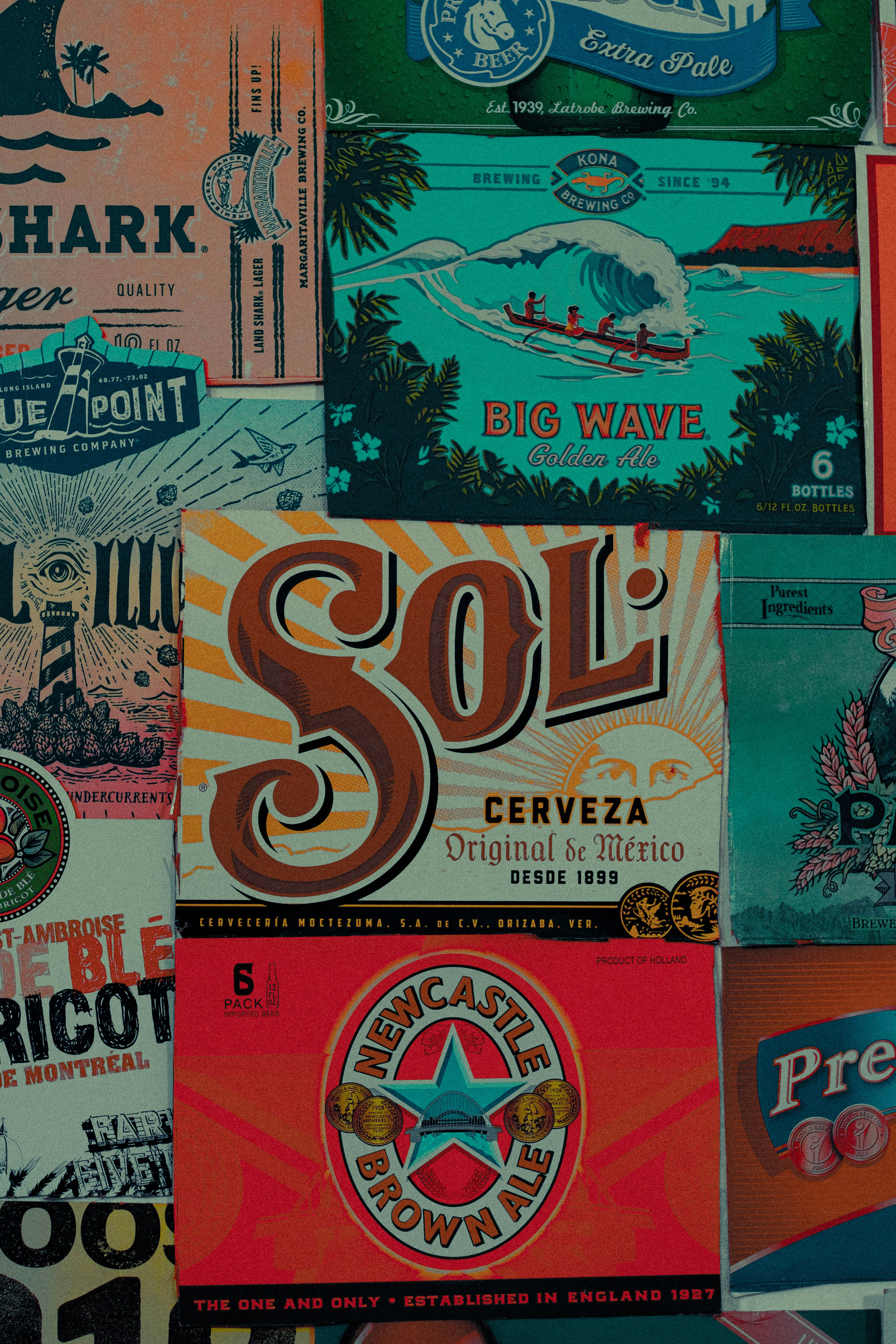 Colorful assortment of vintage beer labels showcasing various brands and designs, including Sol and Newcastle Brown Ale.