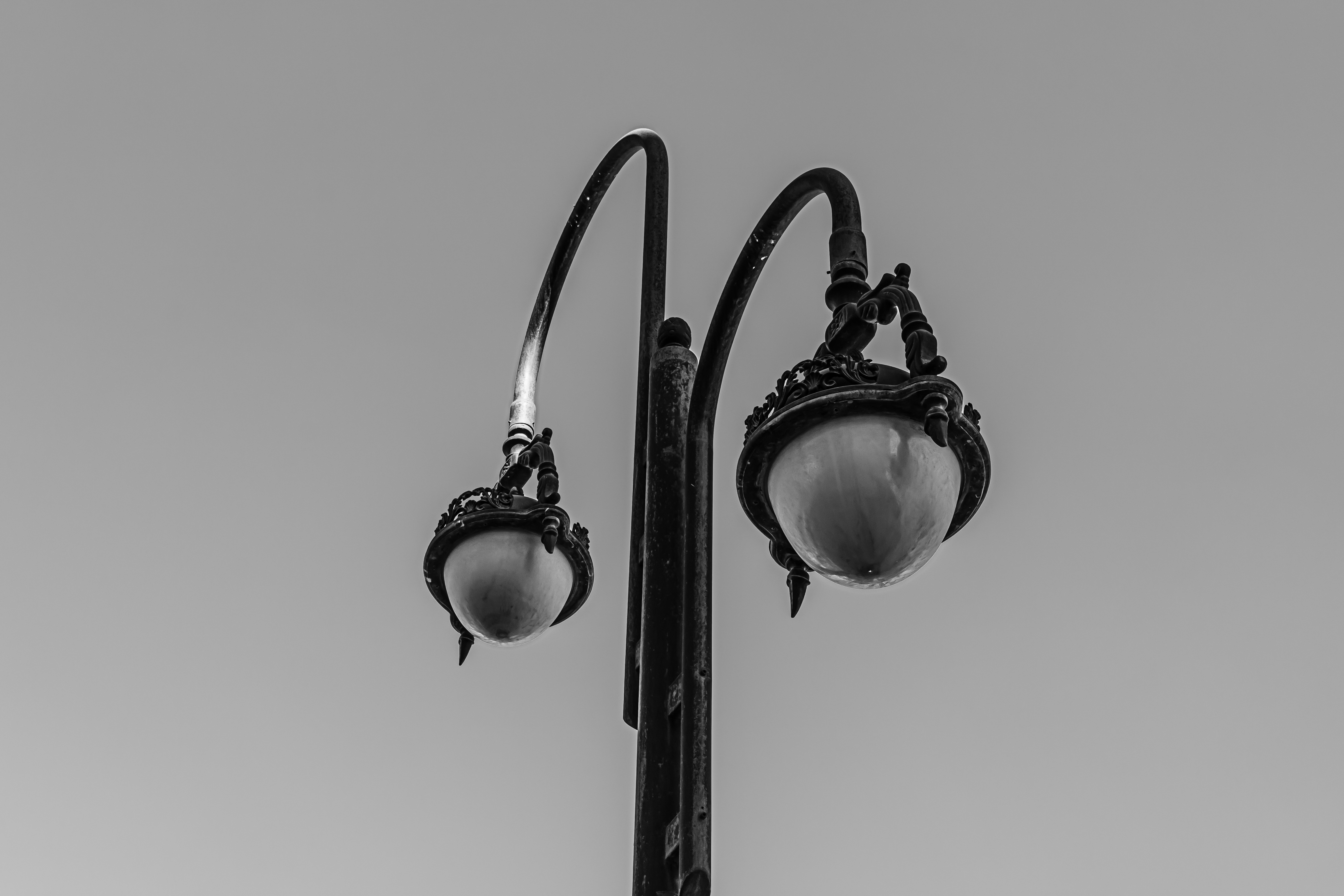 Dual Lanterns on a Curved Post Against a Minimal Sky