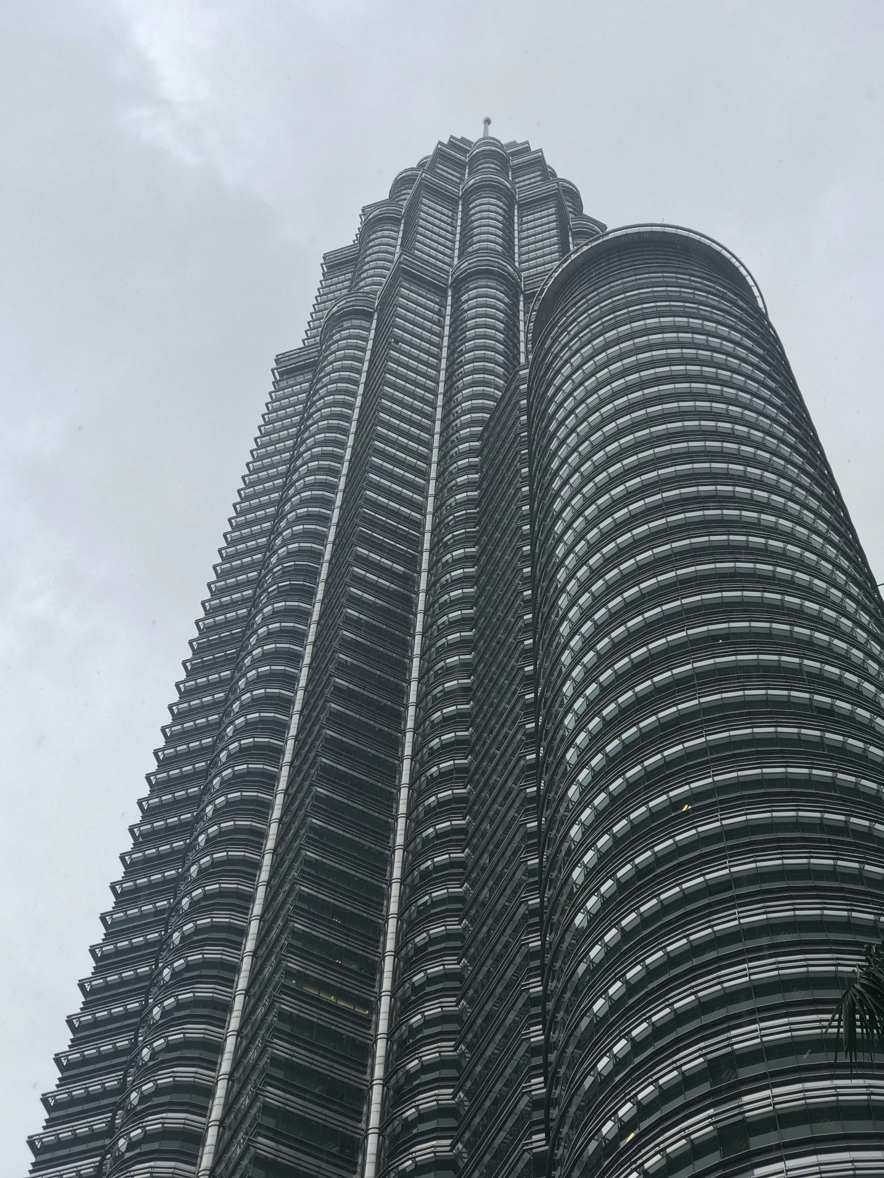 Monochrome Ascent: Ribbed Cylinders Tower Toward a Clouded Summit