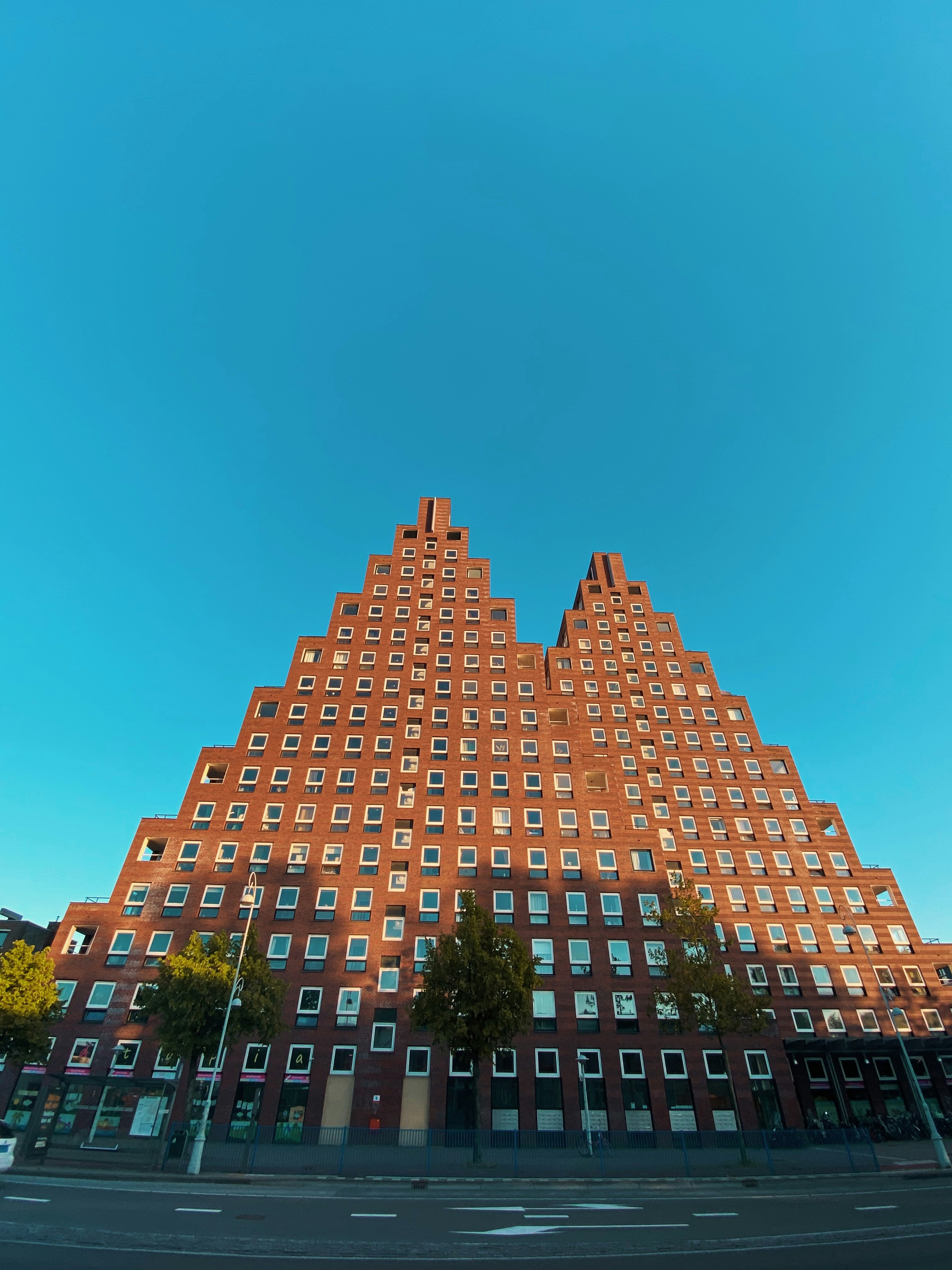 Triangular Peaks of Brick: A City Cliff Above the Street