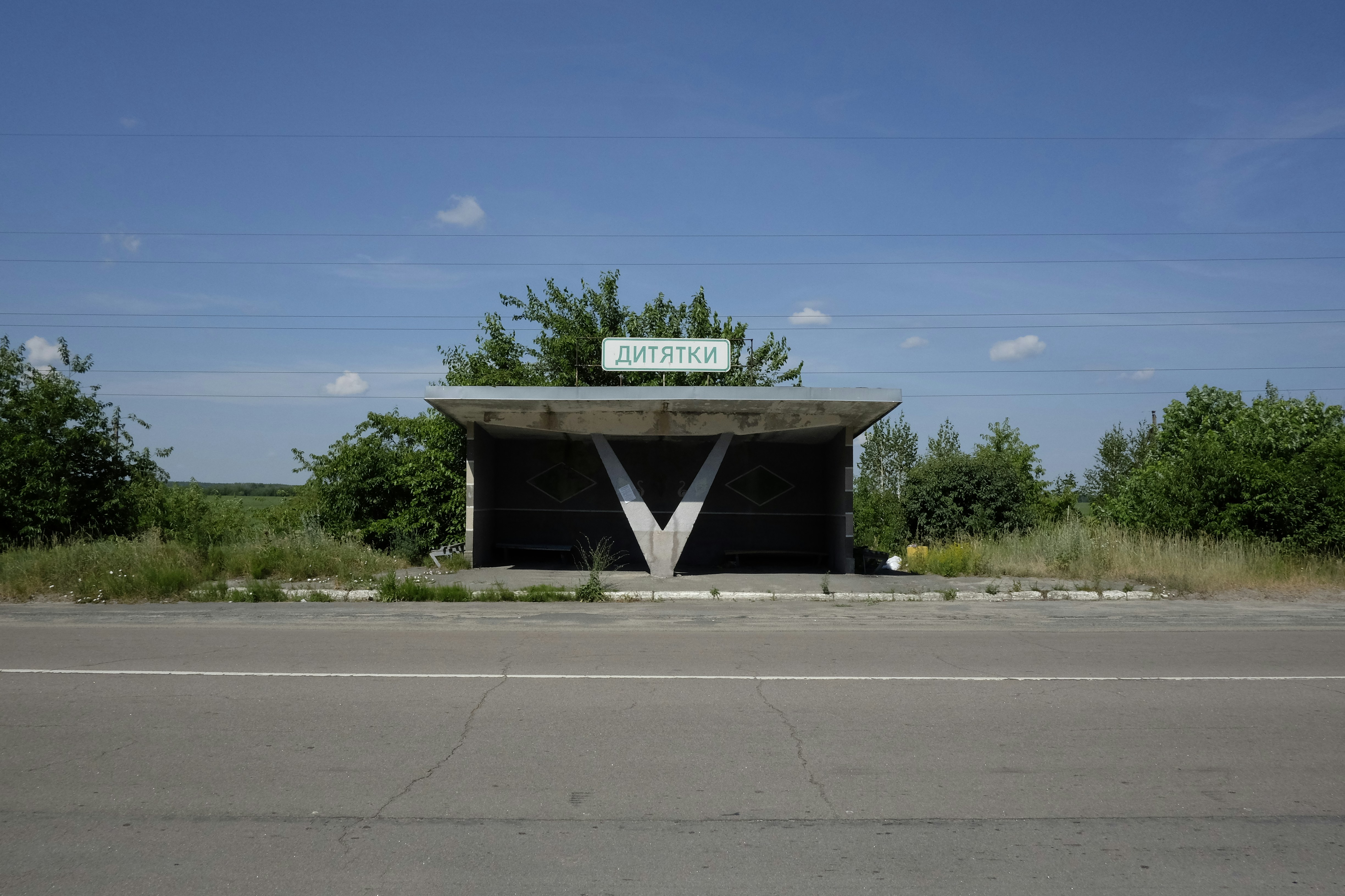 The White V Gateway: A Minimalist Roadside Shelter Under a Clear Blue Sky