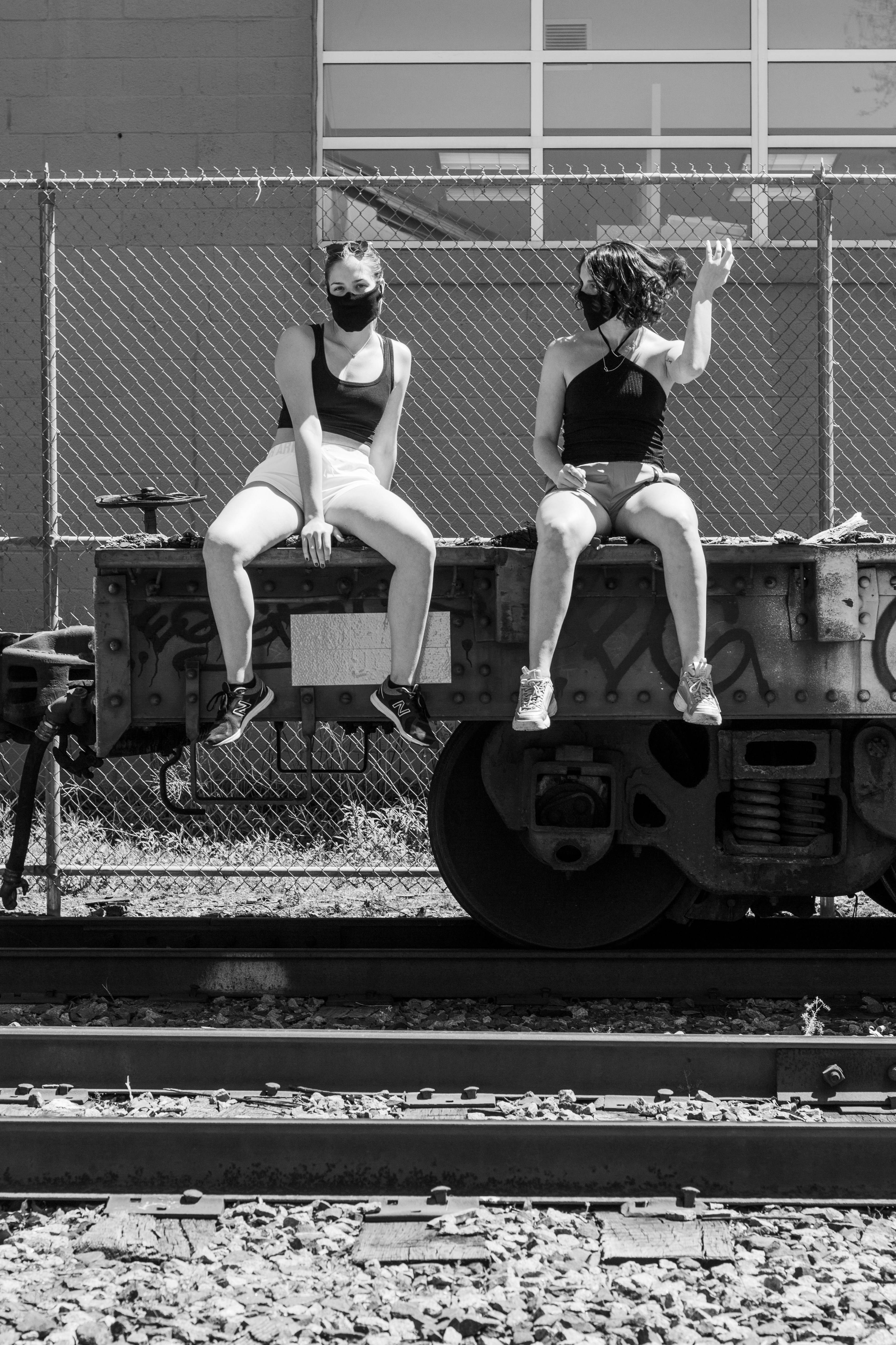 Two Women Break Between Rails: Quiet Defiance on a Graffiti-Sprayed Car