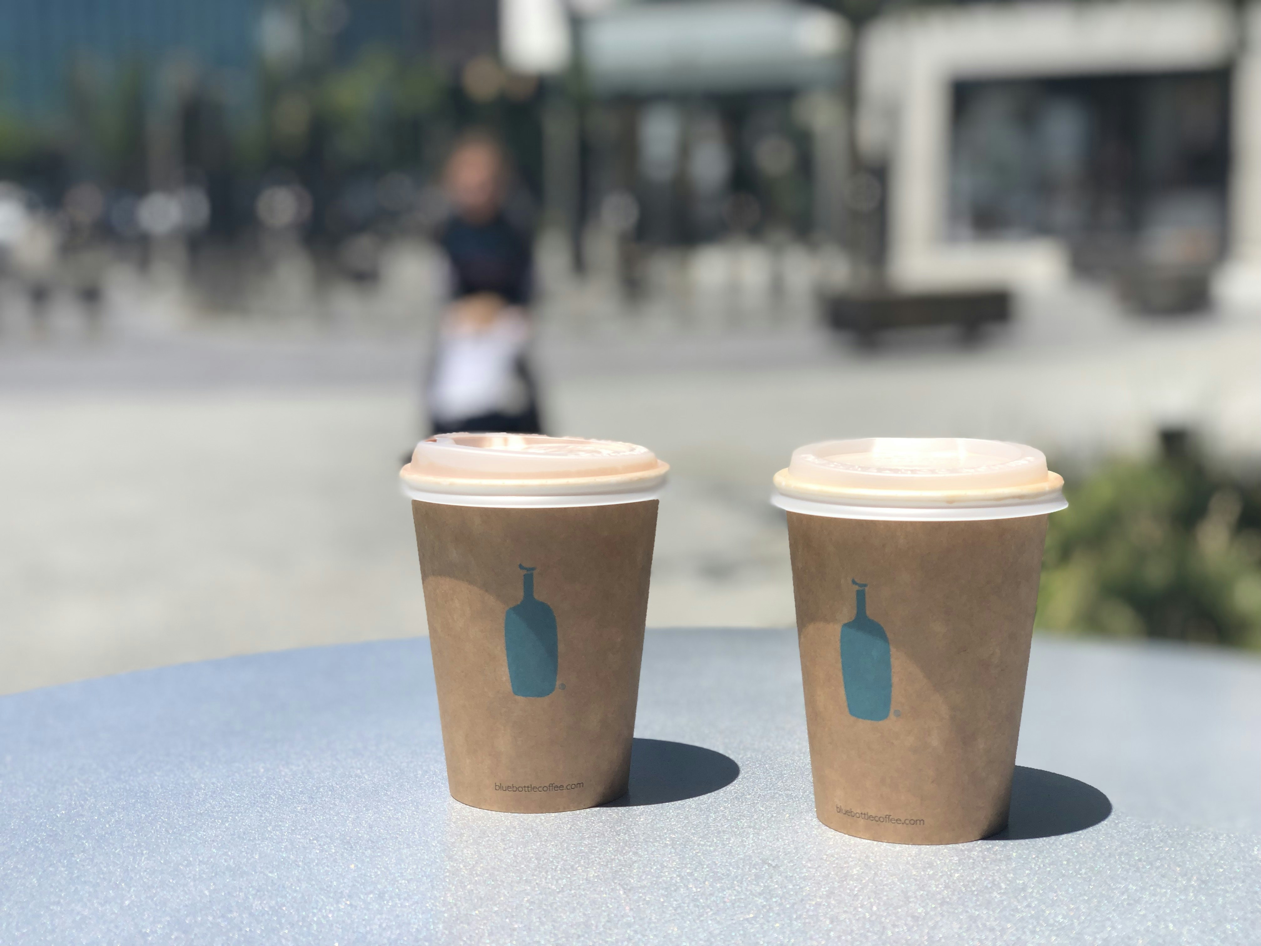 Twin Takeaway Cups Anchor a Sunlit Cafe Table