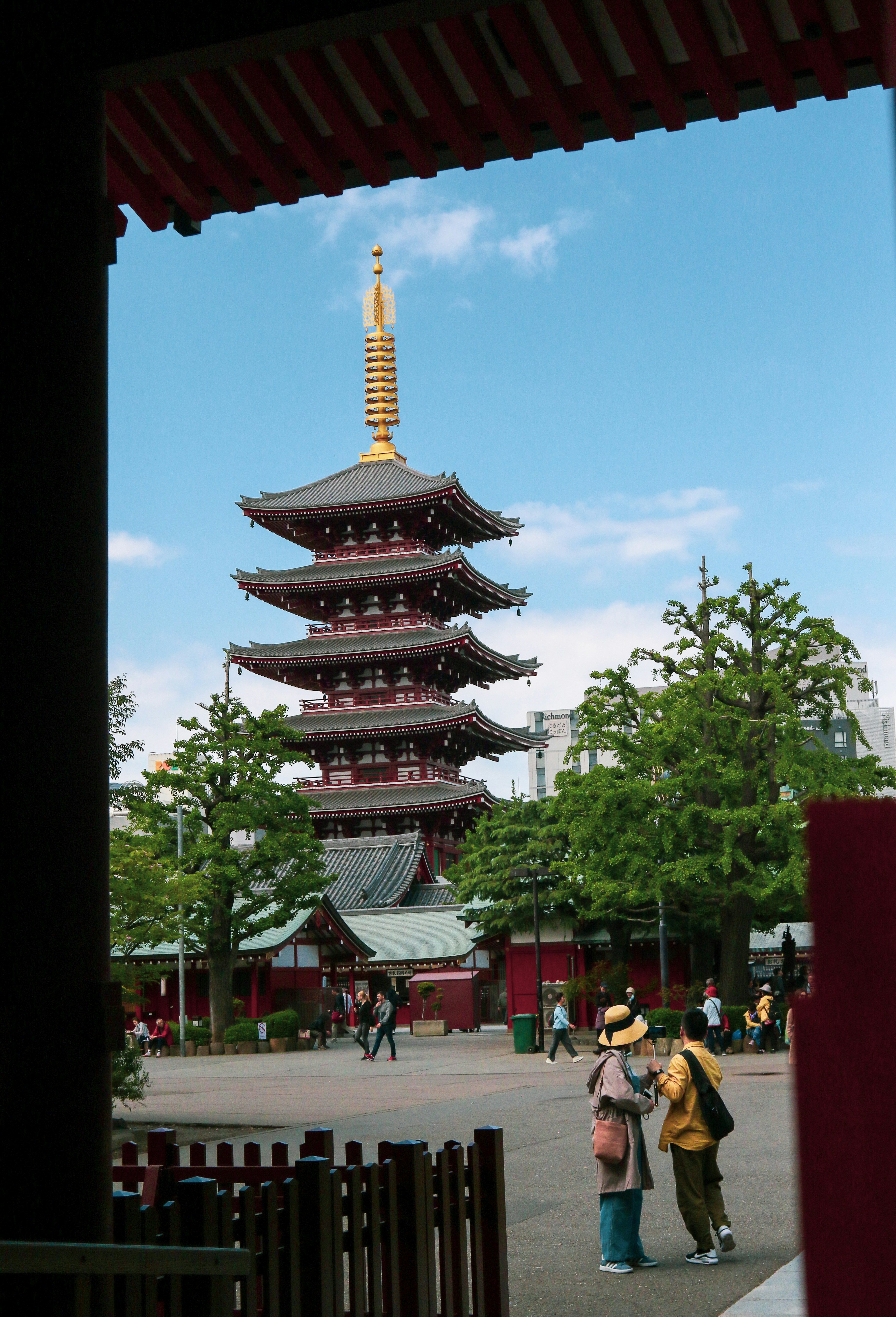 people walking near red and brown temple during daytime