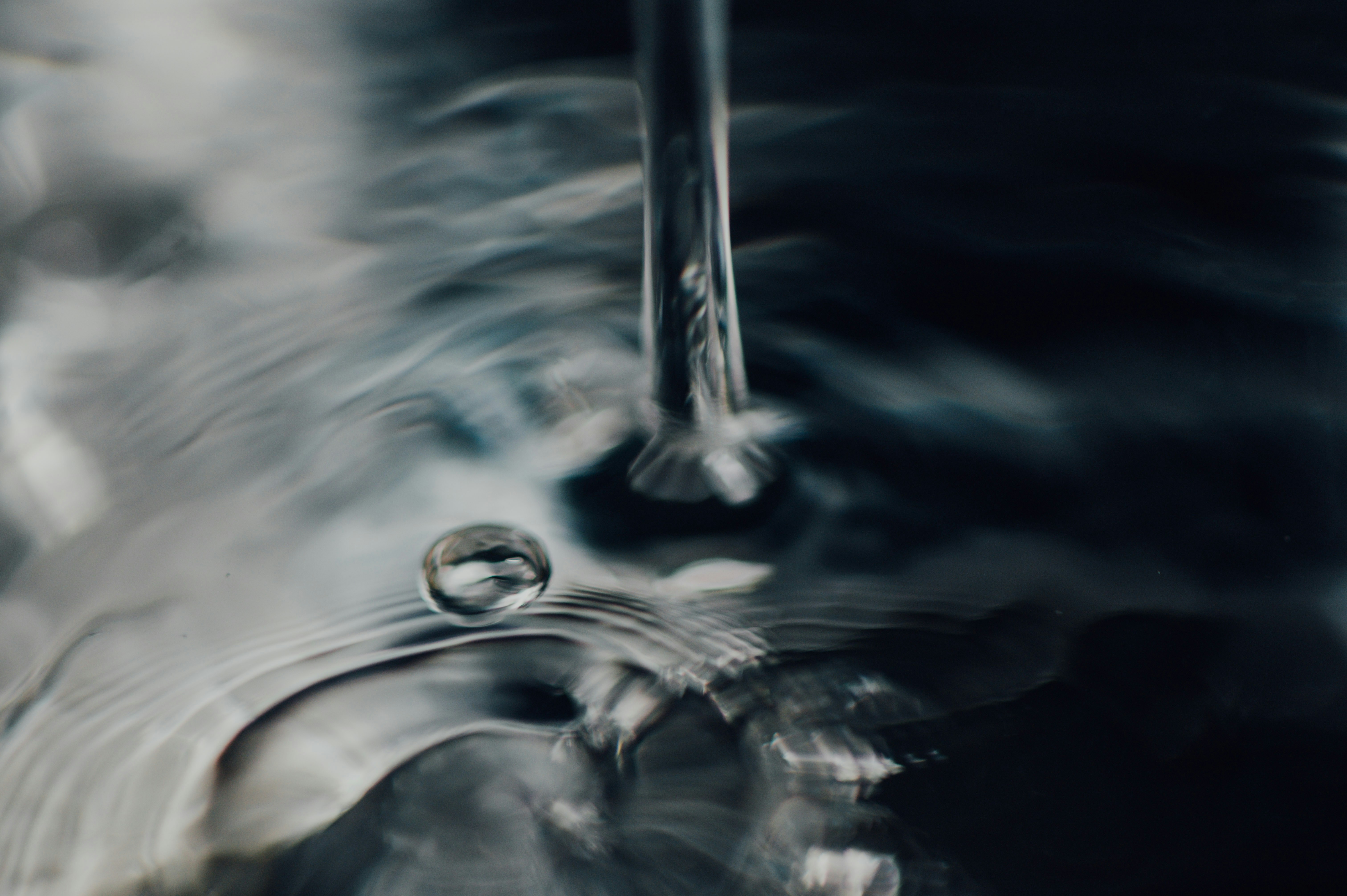 water drop in grayscale photographyCHUTTERSNAP