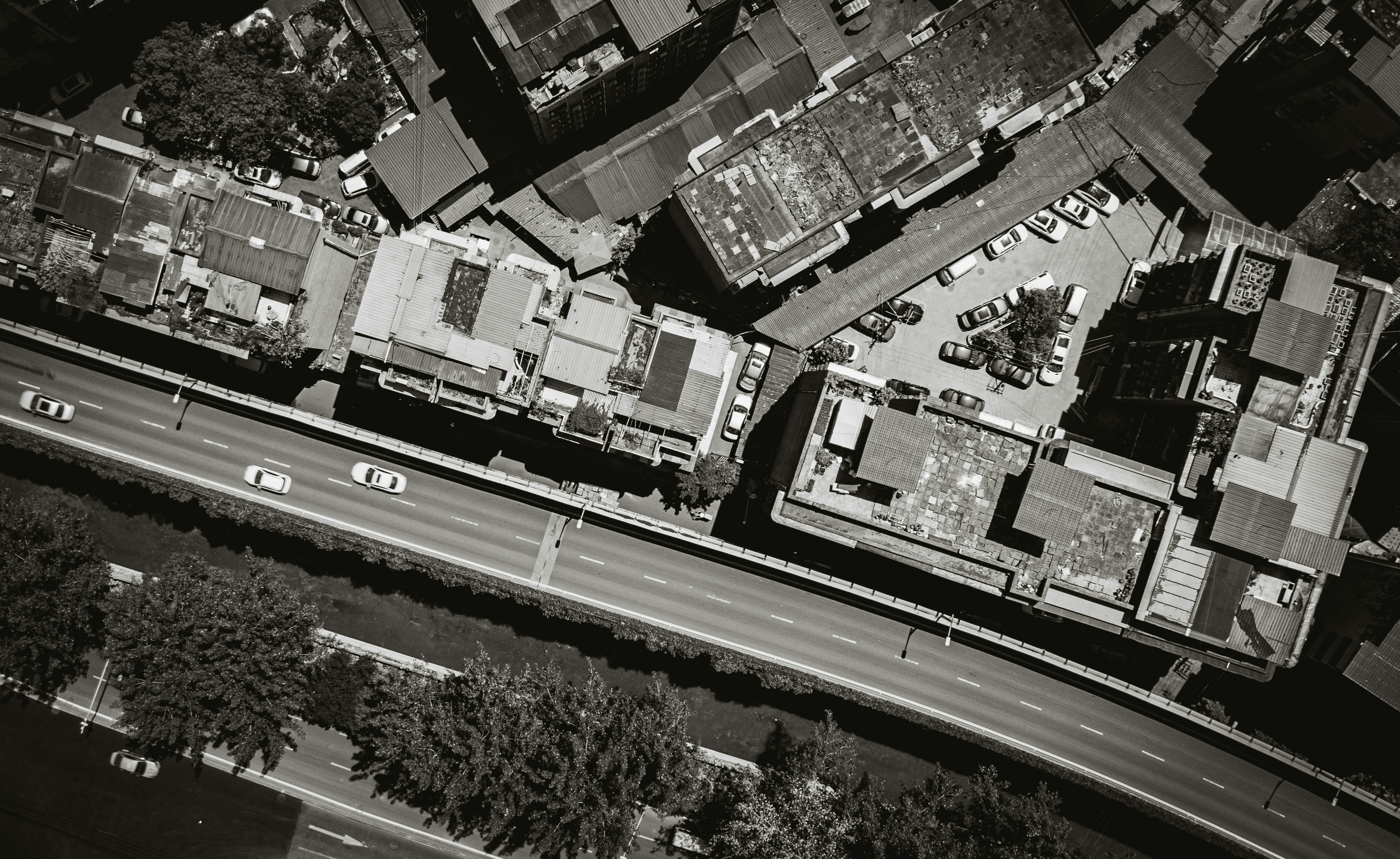 Aerial view of a cityscape showcasing a mix of residential buildings and a busy roadway below, highlighting the intricate layout of urban living.