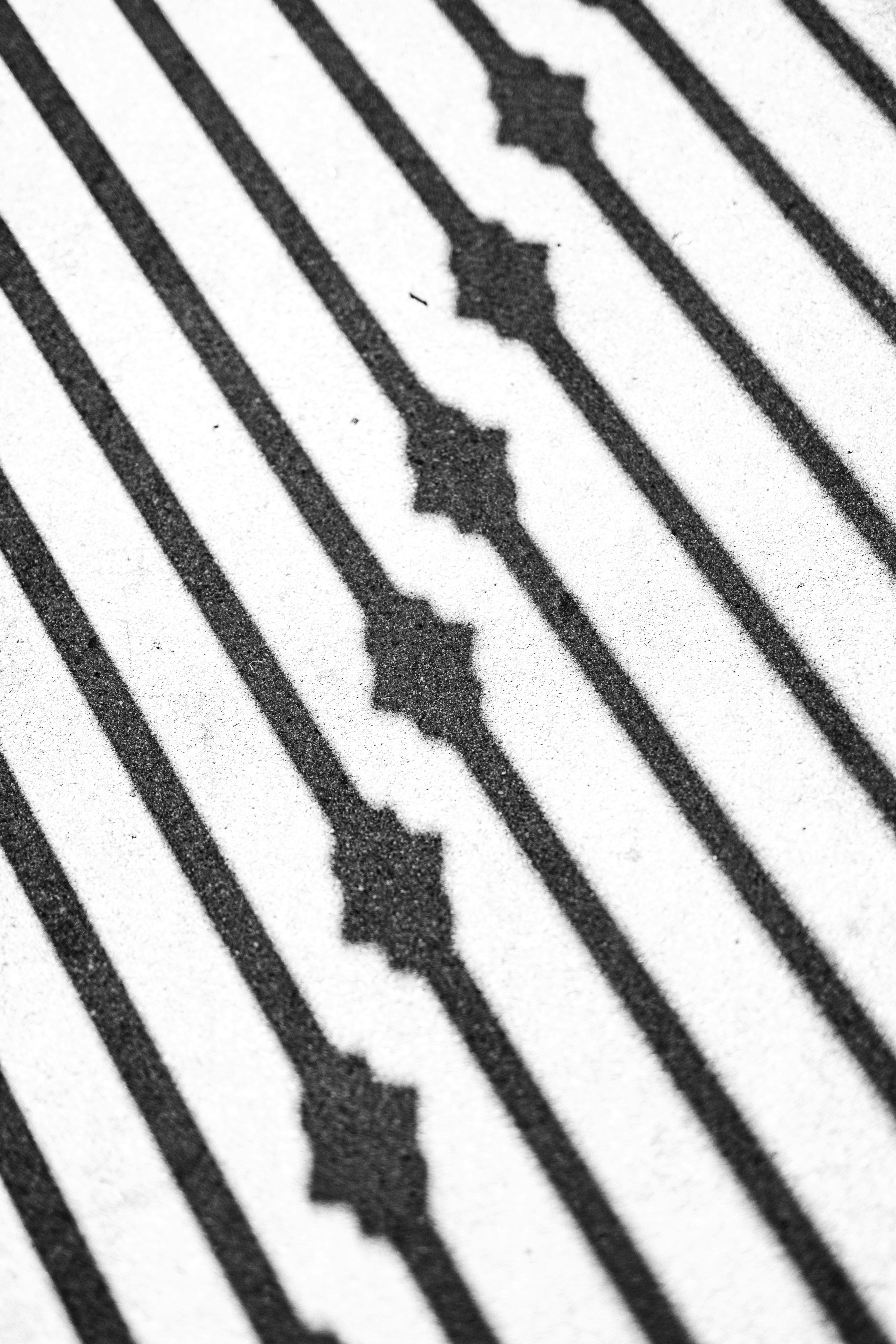 High-contrast grayscale pattern of diagonal lines with star-shaped nodes creating a repetitive rhythm; abstract geometric texture suitable for typography or design study.