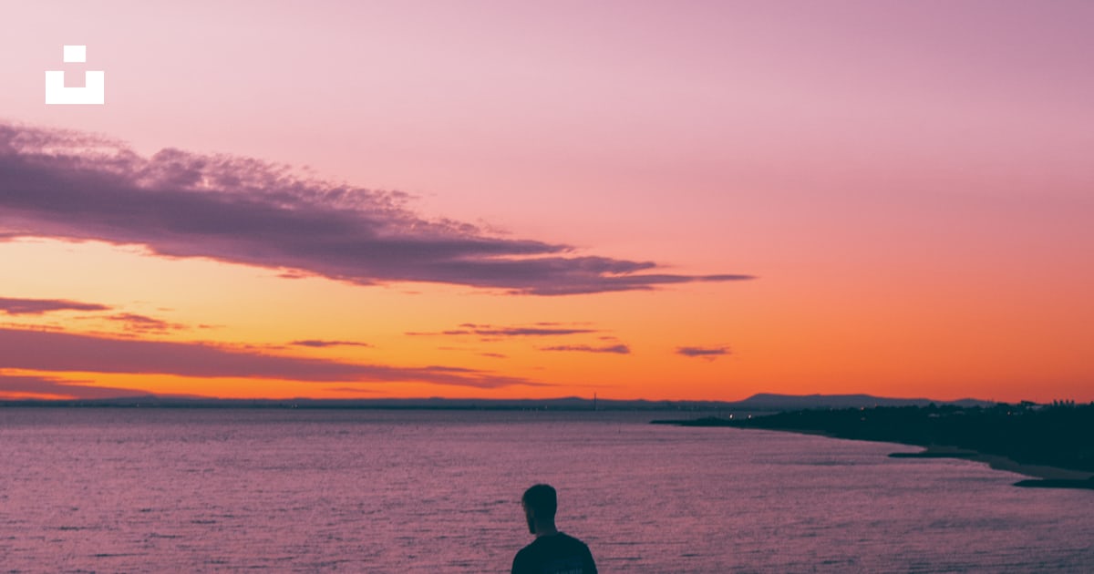 Foto Silueta De La Persona De Pie En La Playa Durante La Puesta Del Sol