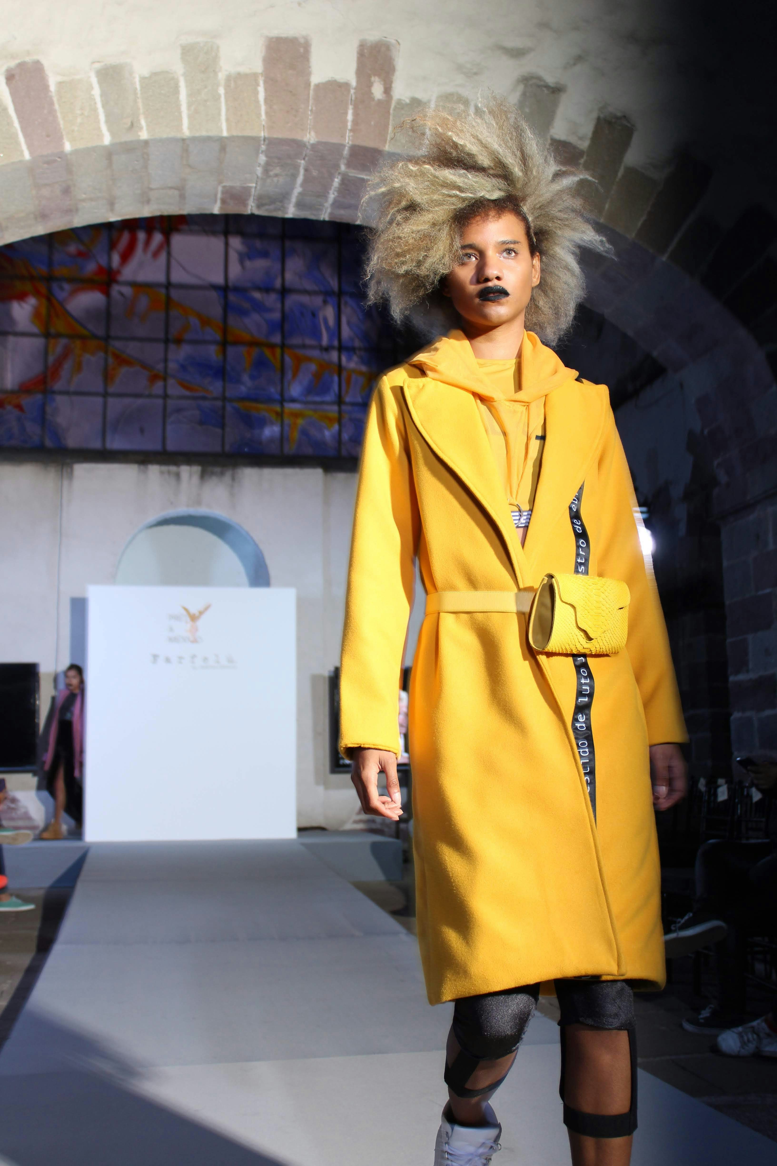Amber Runner: Bold Yellow Coat Commands the Archway Runway