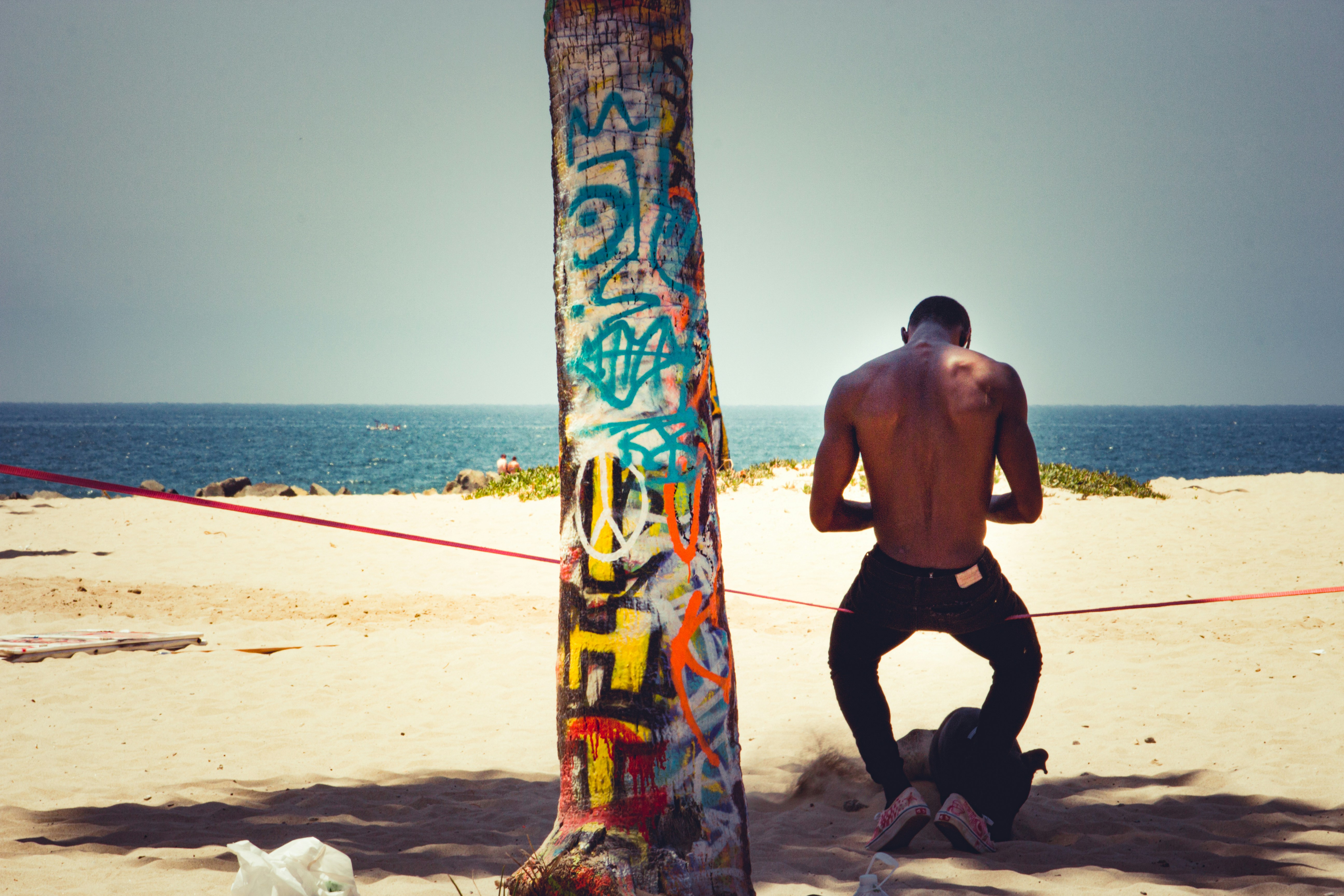 Shadows and Spray: a Surfer Silhouette by Graffitied Pillar