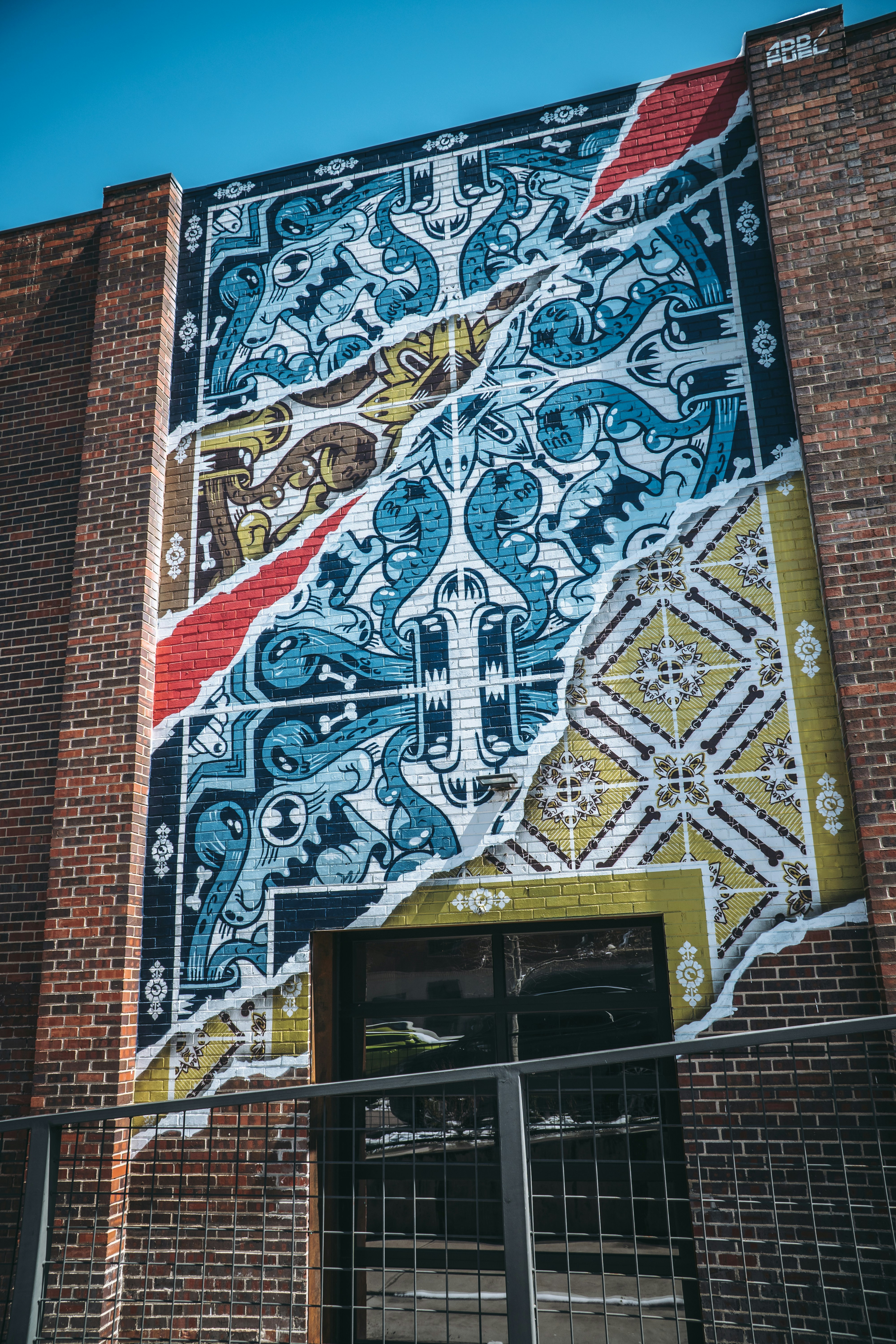 Mosaic Façade: A Brick Wall Adorned with Interwoven Blues and Golden Patterns
