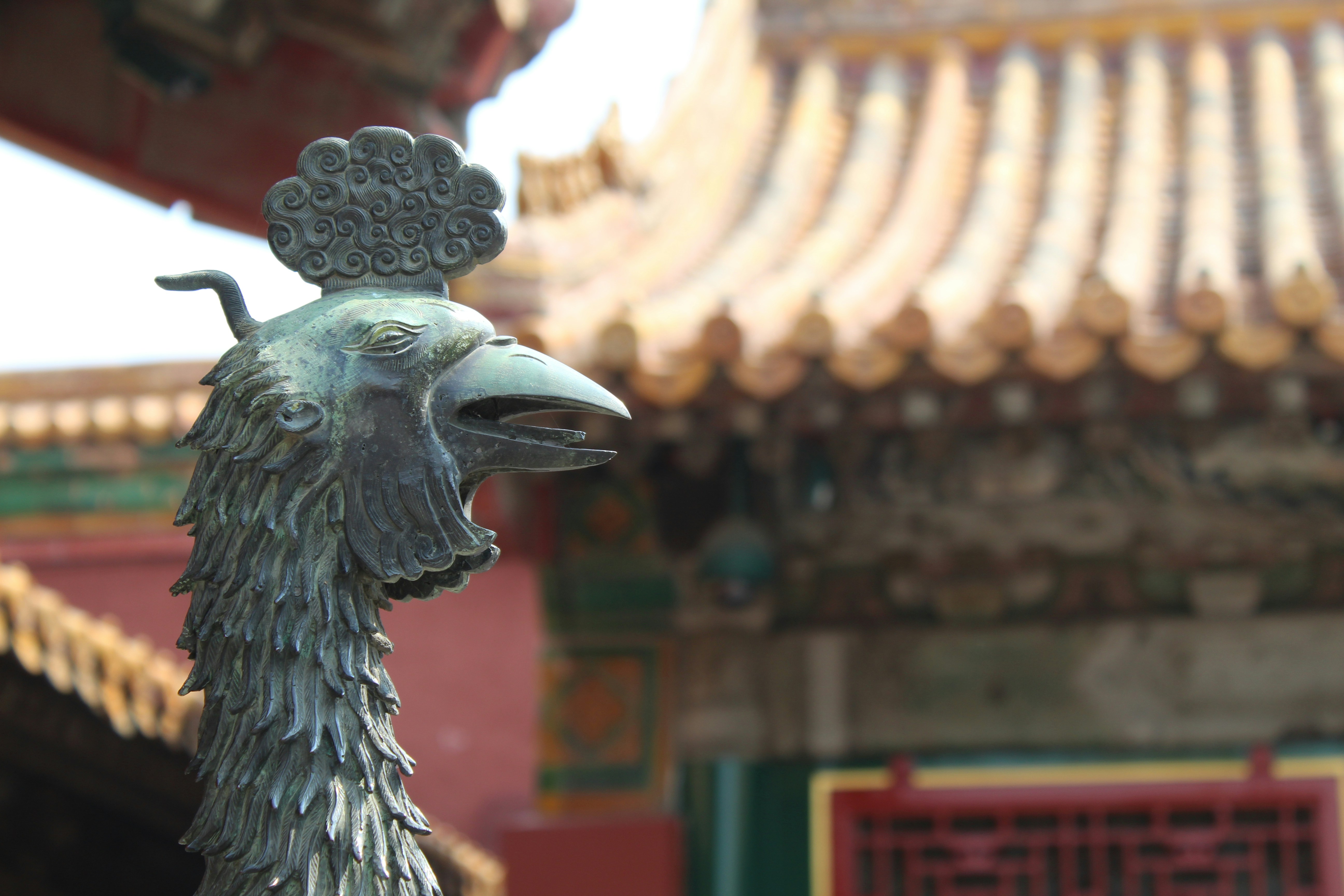 Bronze Phoenix Guardian Framing a Traditional Temple Roof