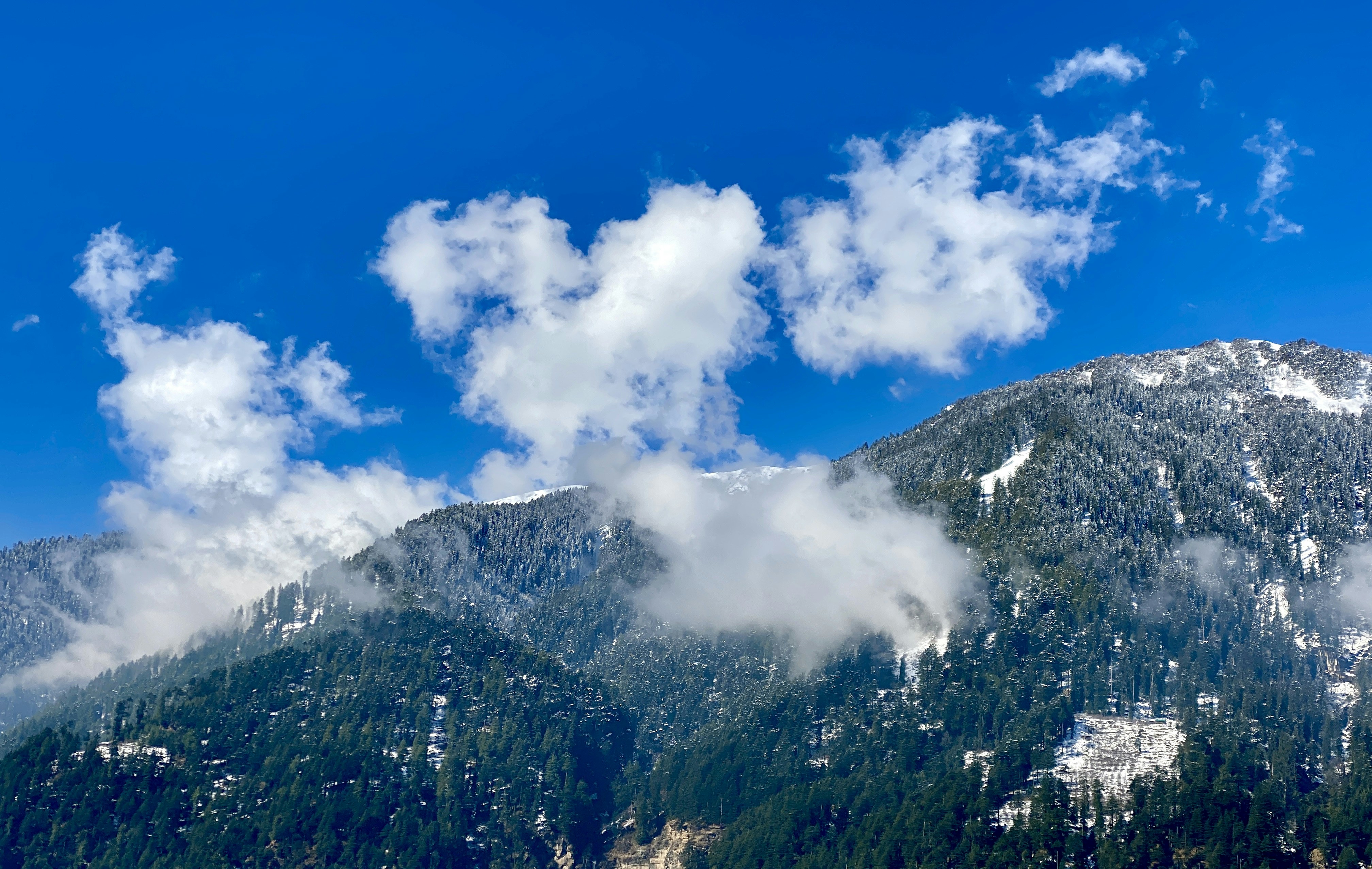 Mountains with snow and trees and clouds