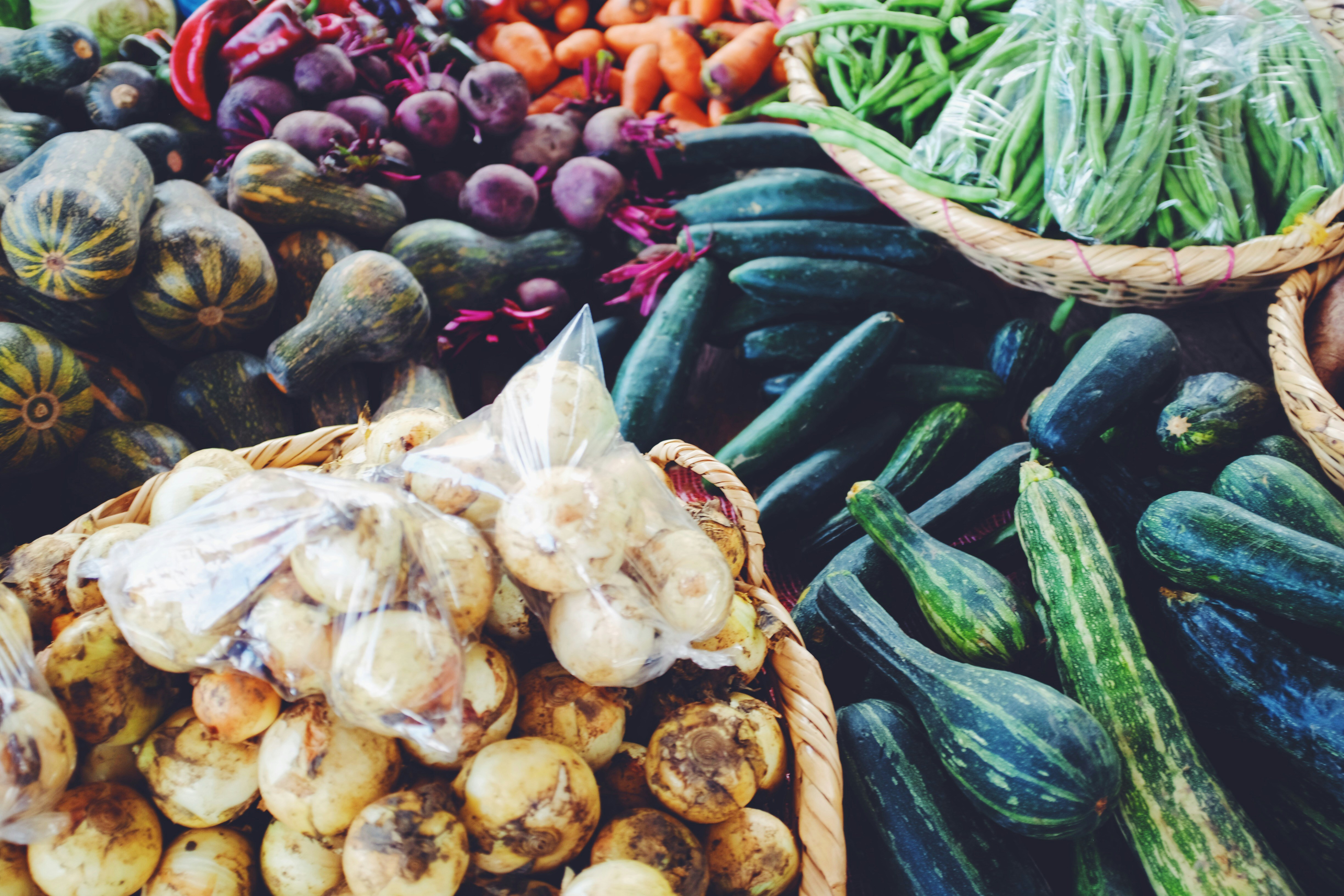 Vibrant assortment of fresh vegetables displayed in baskets at a market, showcasing a variety of colors and textures.
