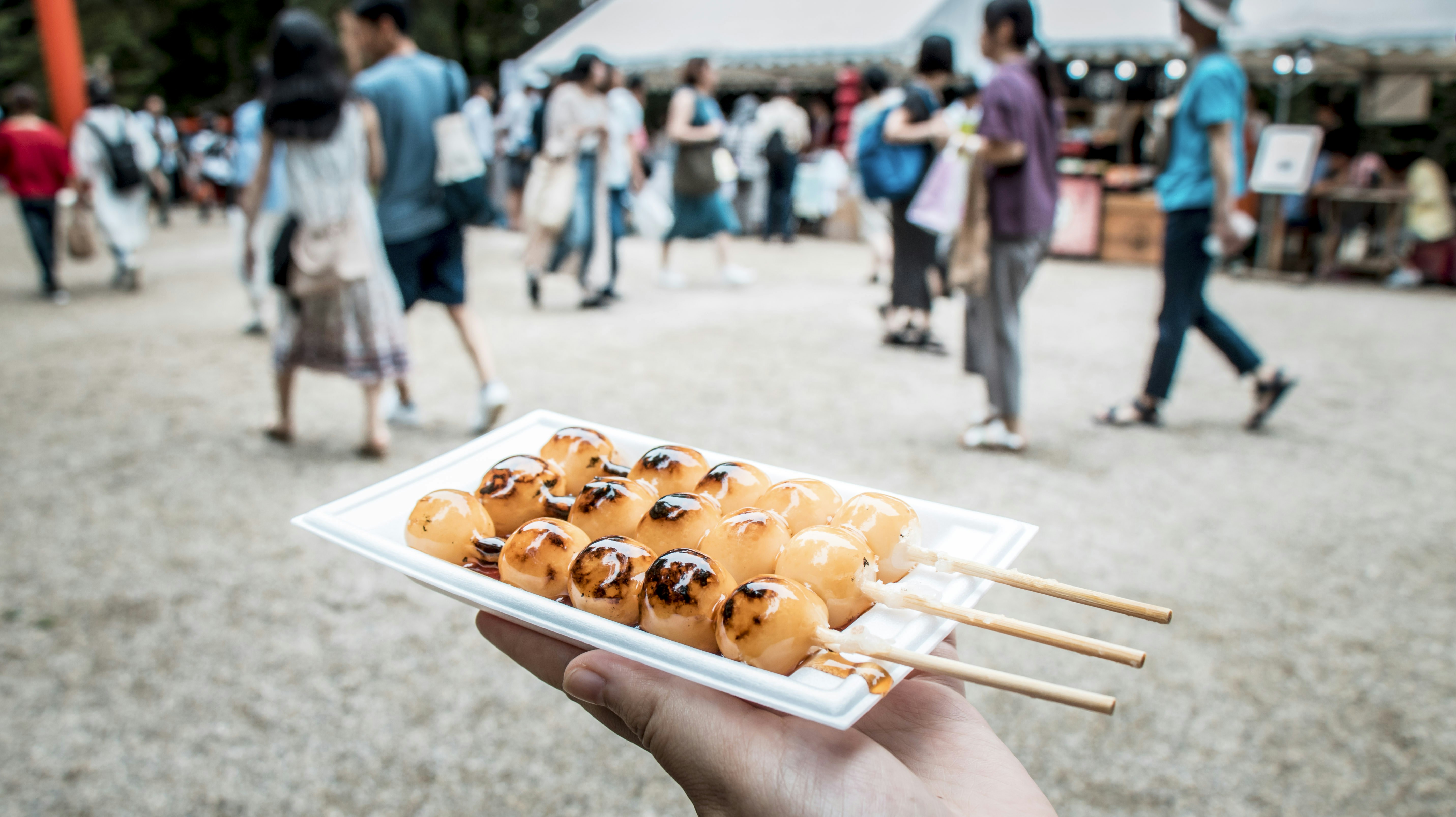 Skewered Sweetness: Grilled Mochi Treats Held at a Lively Street Fair