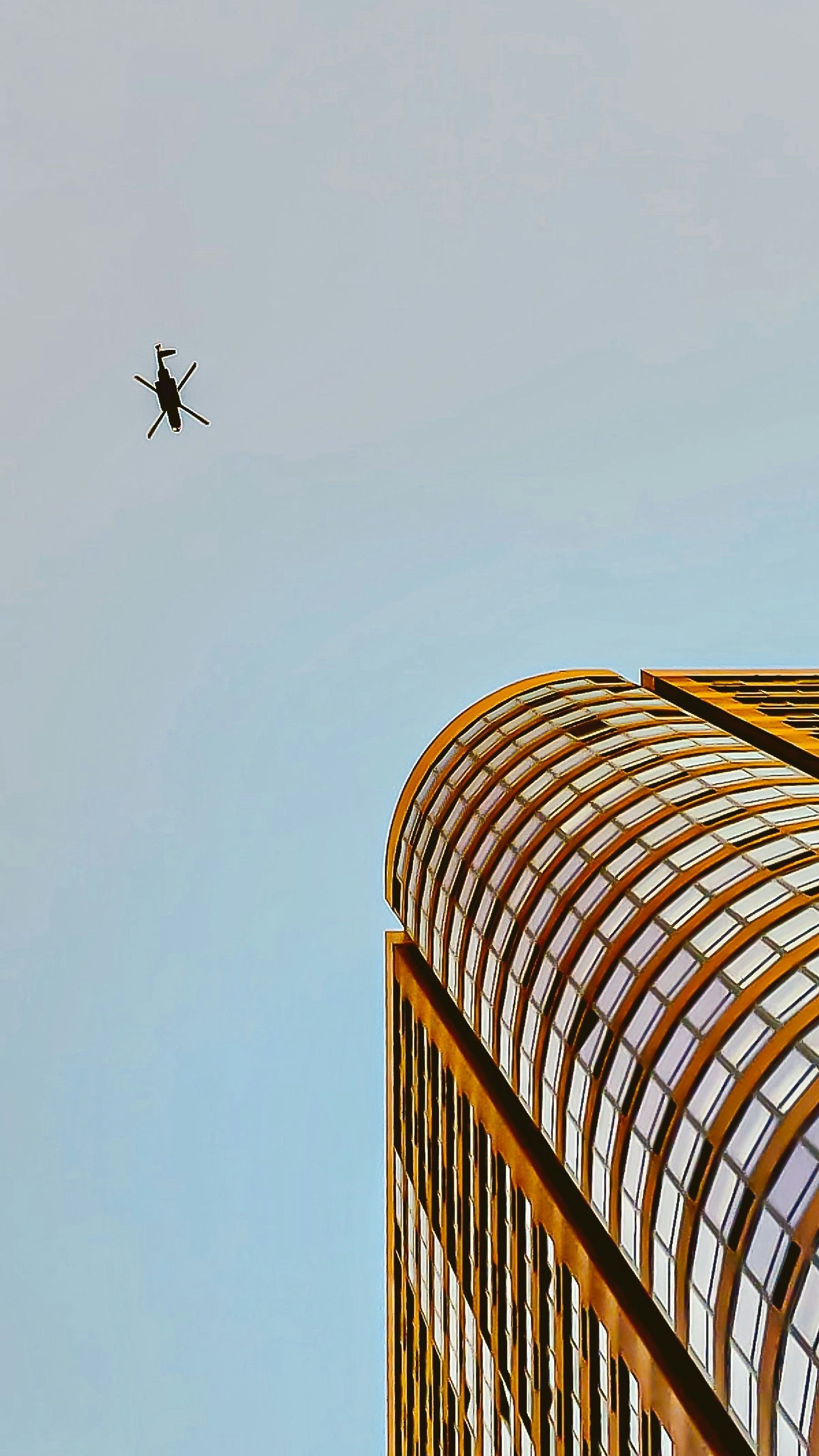 Helicopter Above the Golden Facade: A Modern Tower in Perspective