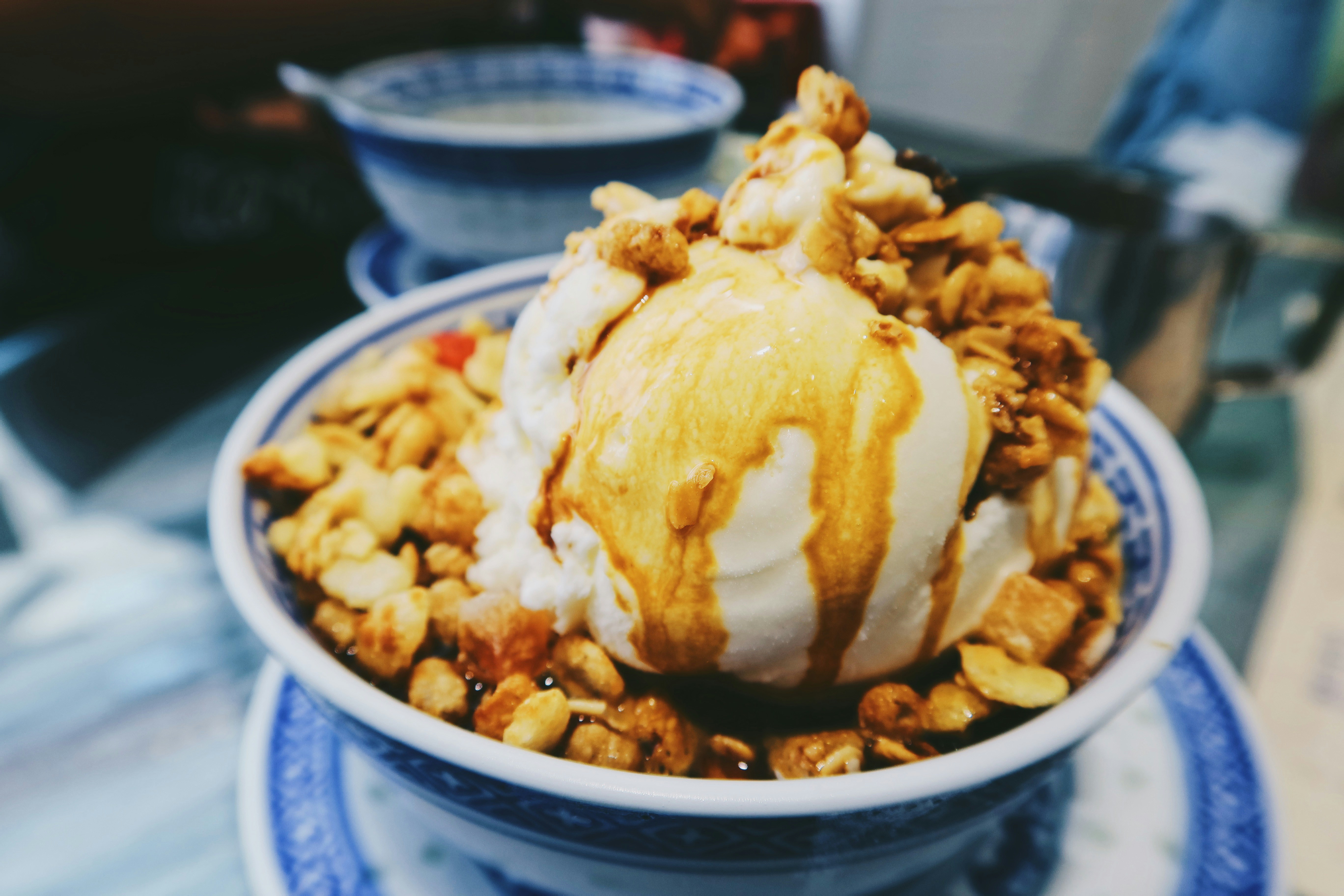 Caramel Crown: Vanilla Ice Cream in a Cerulean Bowl with Crunchy Toppings