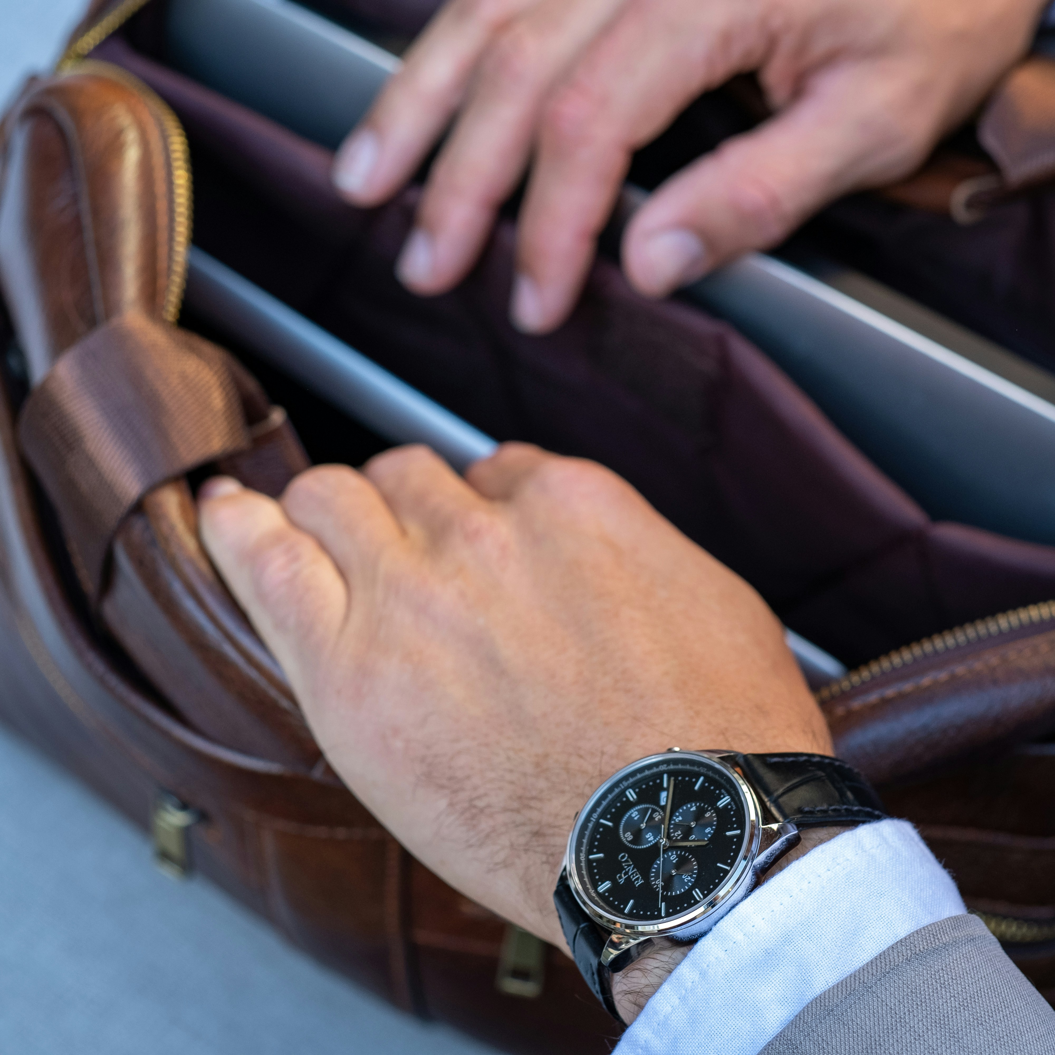 Timekeeper at the Threshold: Unzipping a Brown Leather Bag
