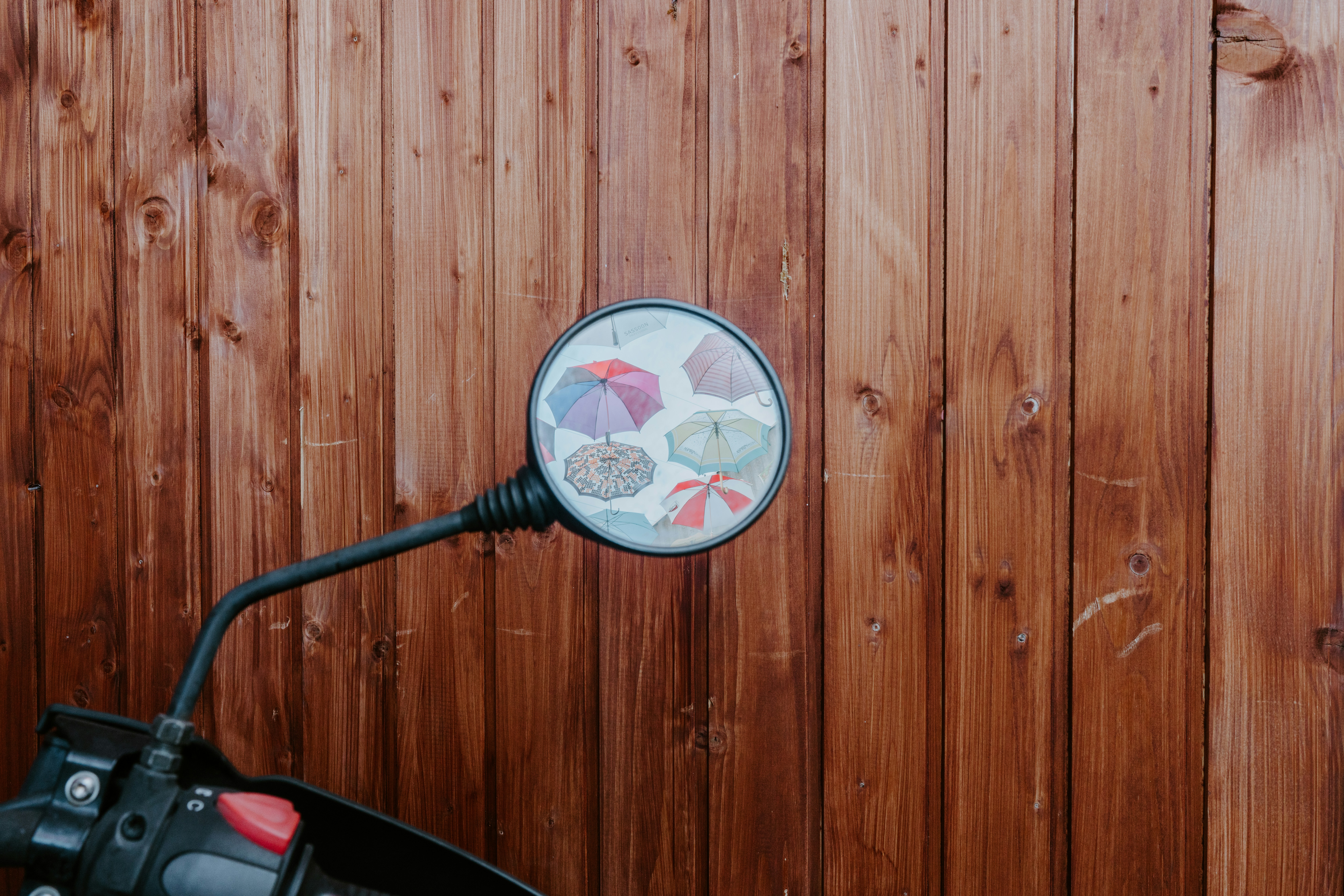 Circle of Color: Umbrellas Reflected in a Motorcycle Mirror