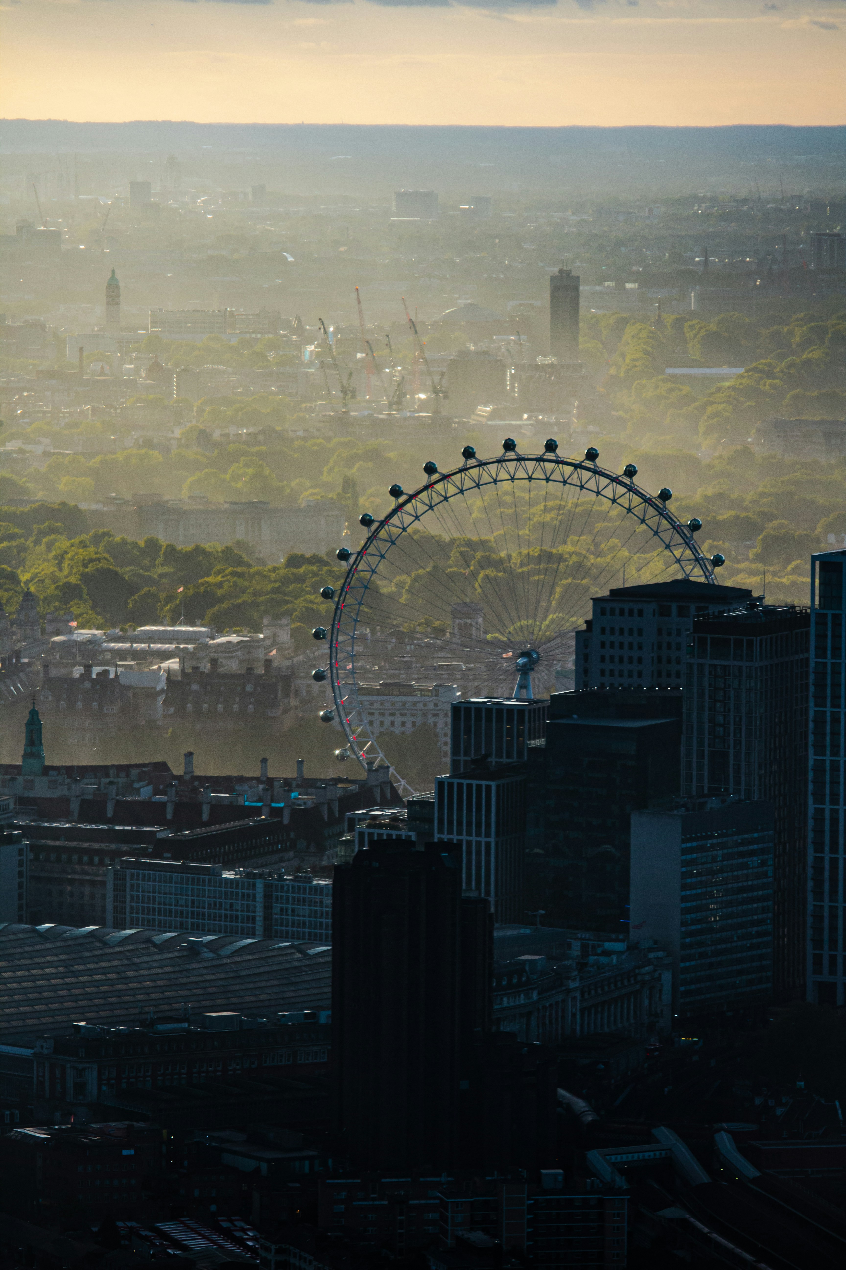 Dawn over London: the London Eye emerges from morning haze above a quiet cityscape