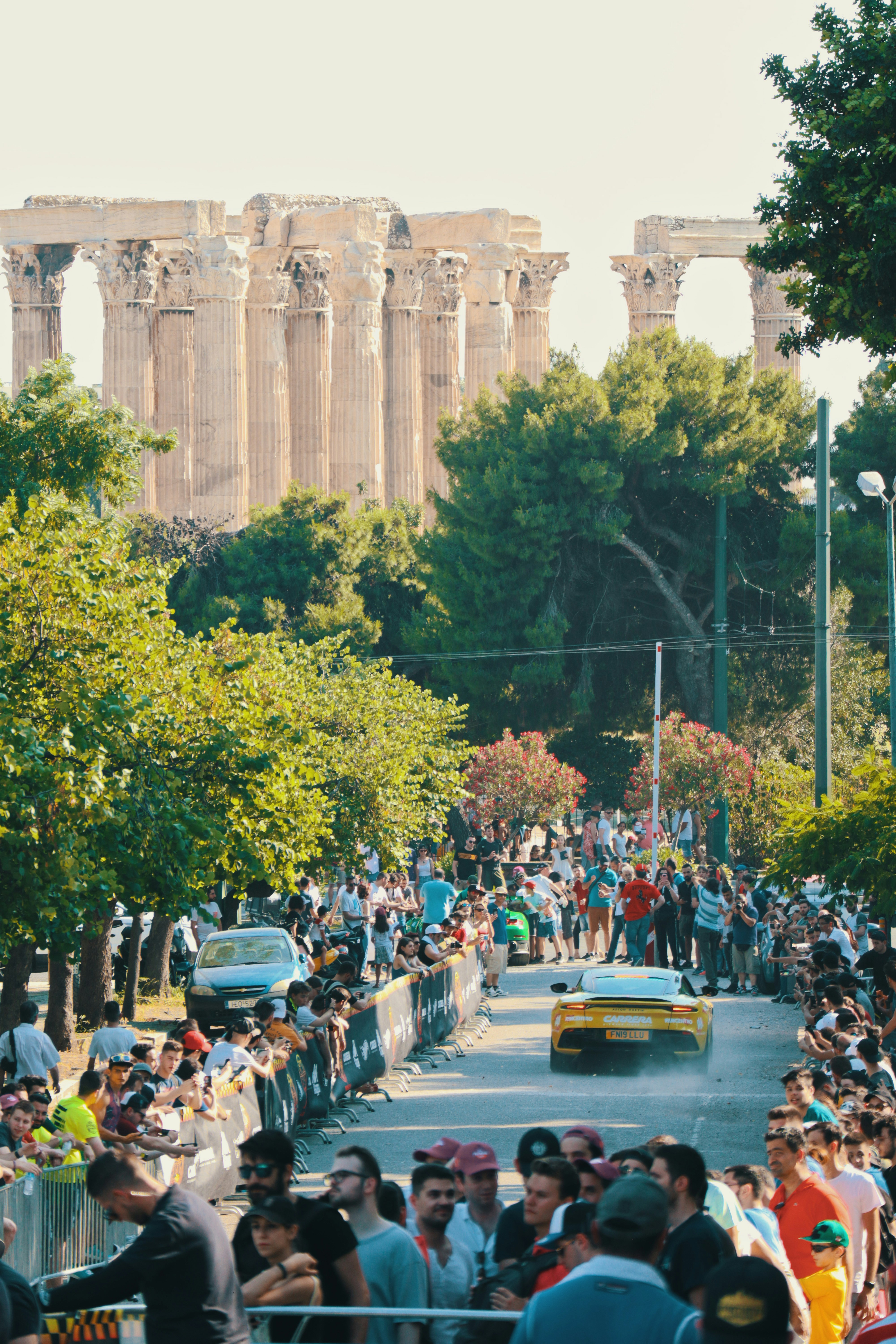 Sunlit Street Rally Beneath Ancient Arches
