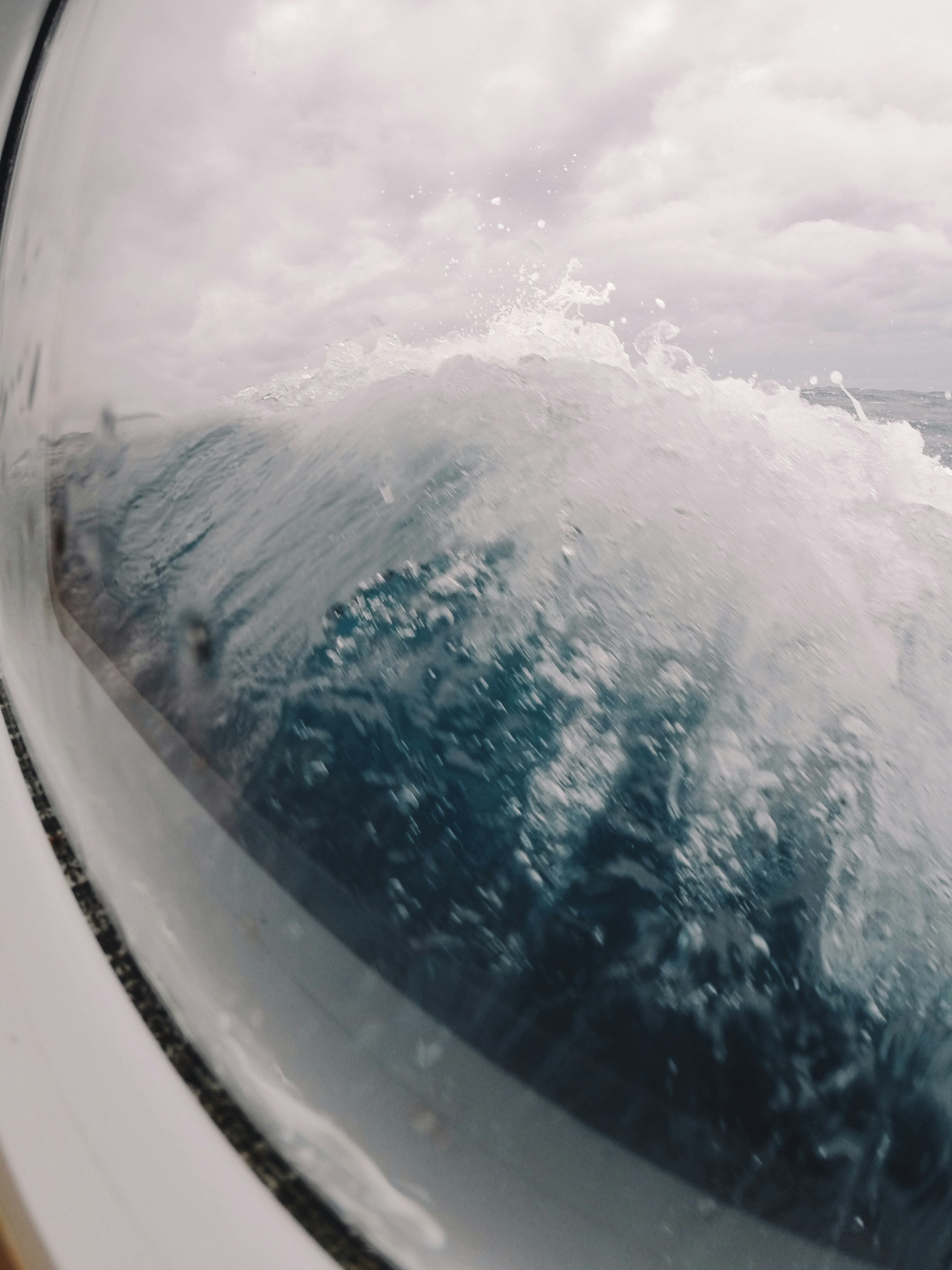 Glassbound Crest: A Wave Burst Through a Porthole
