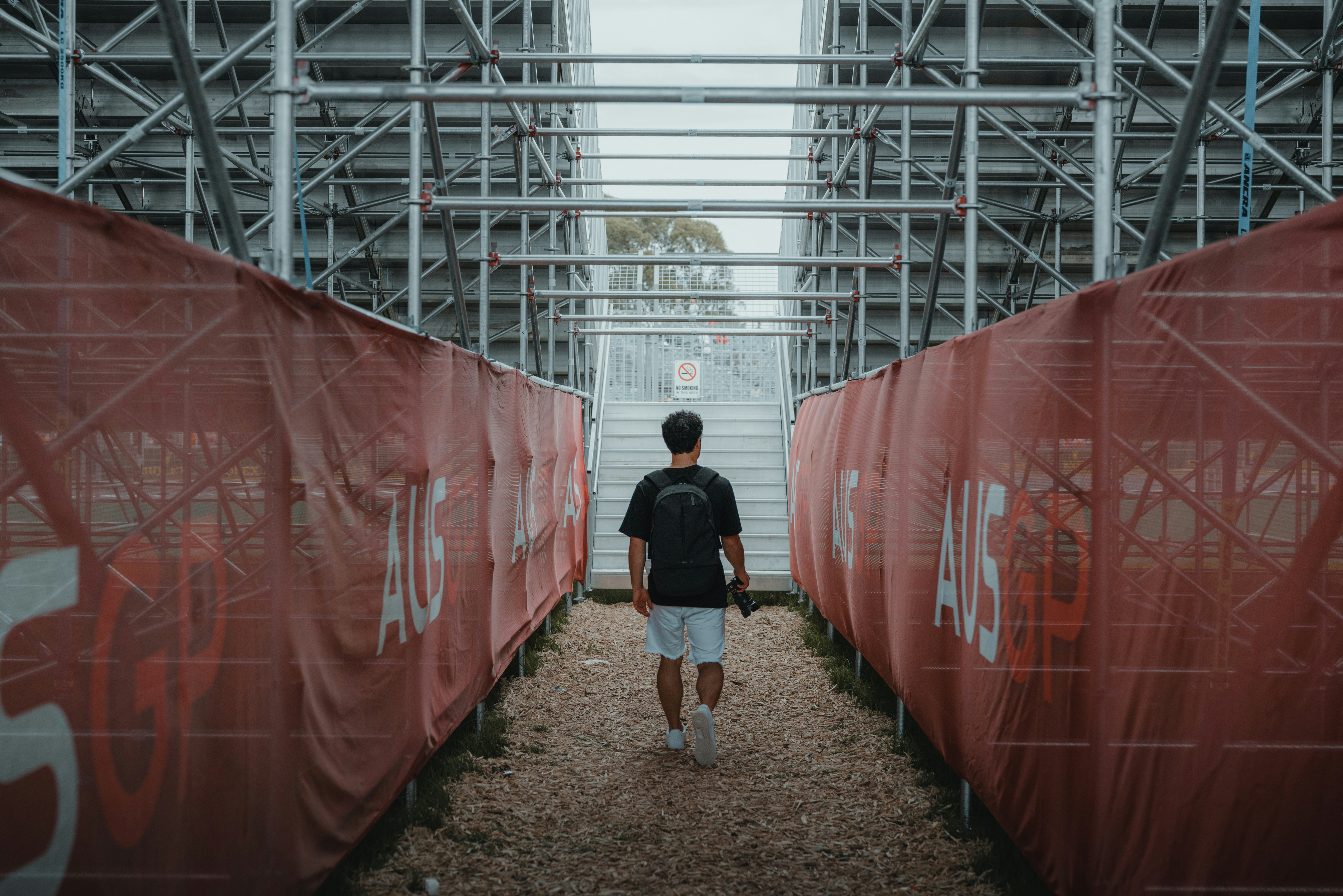Through the Red Barricade: A Lone Walk Beneath Steel