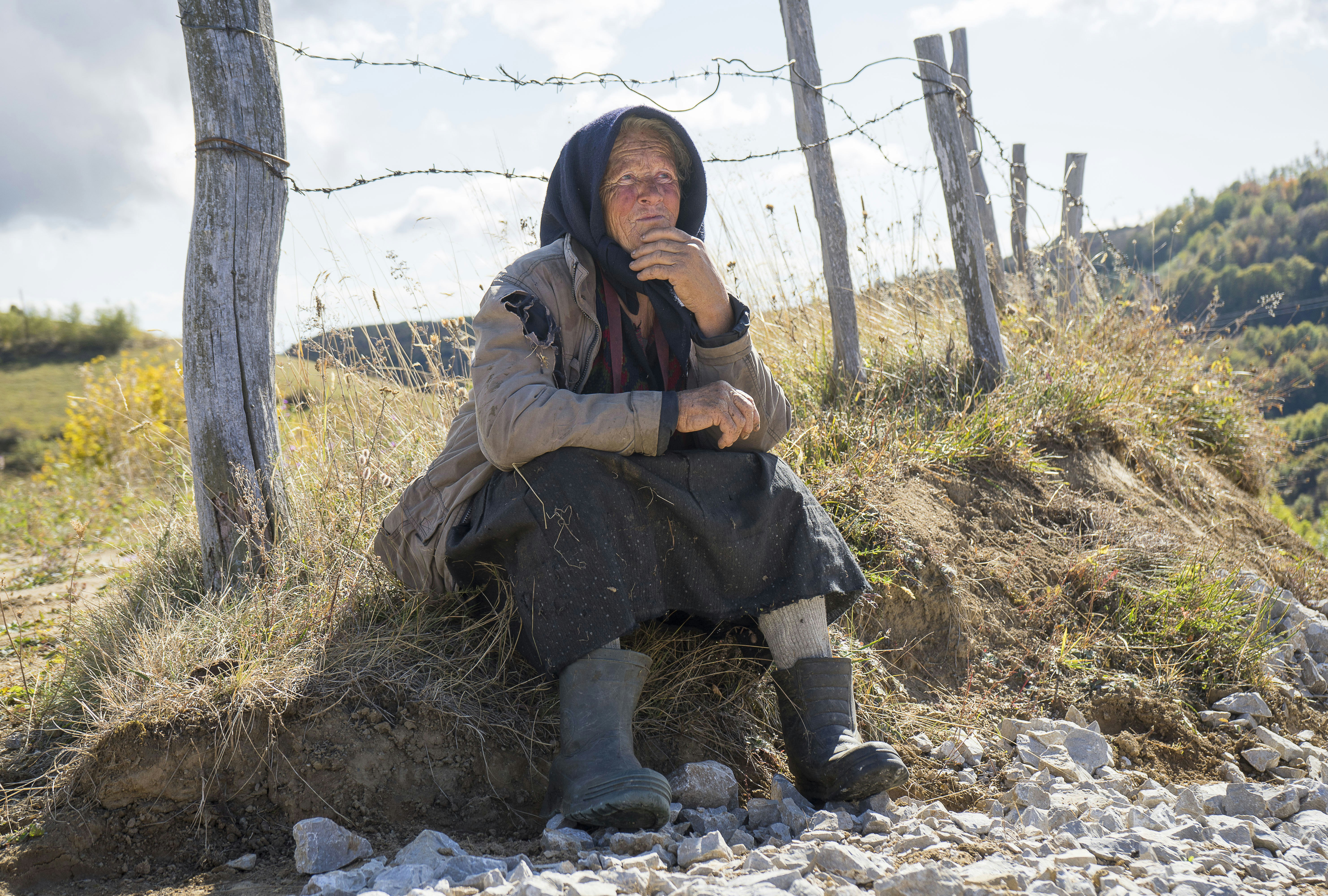 Hollowed Hilltop: A Seated Survivor in Ragged Light