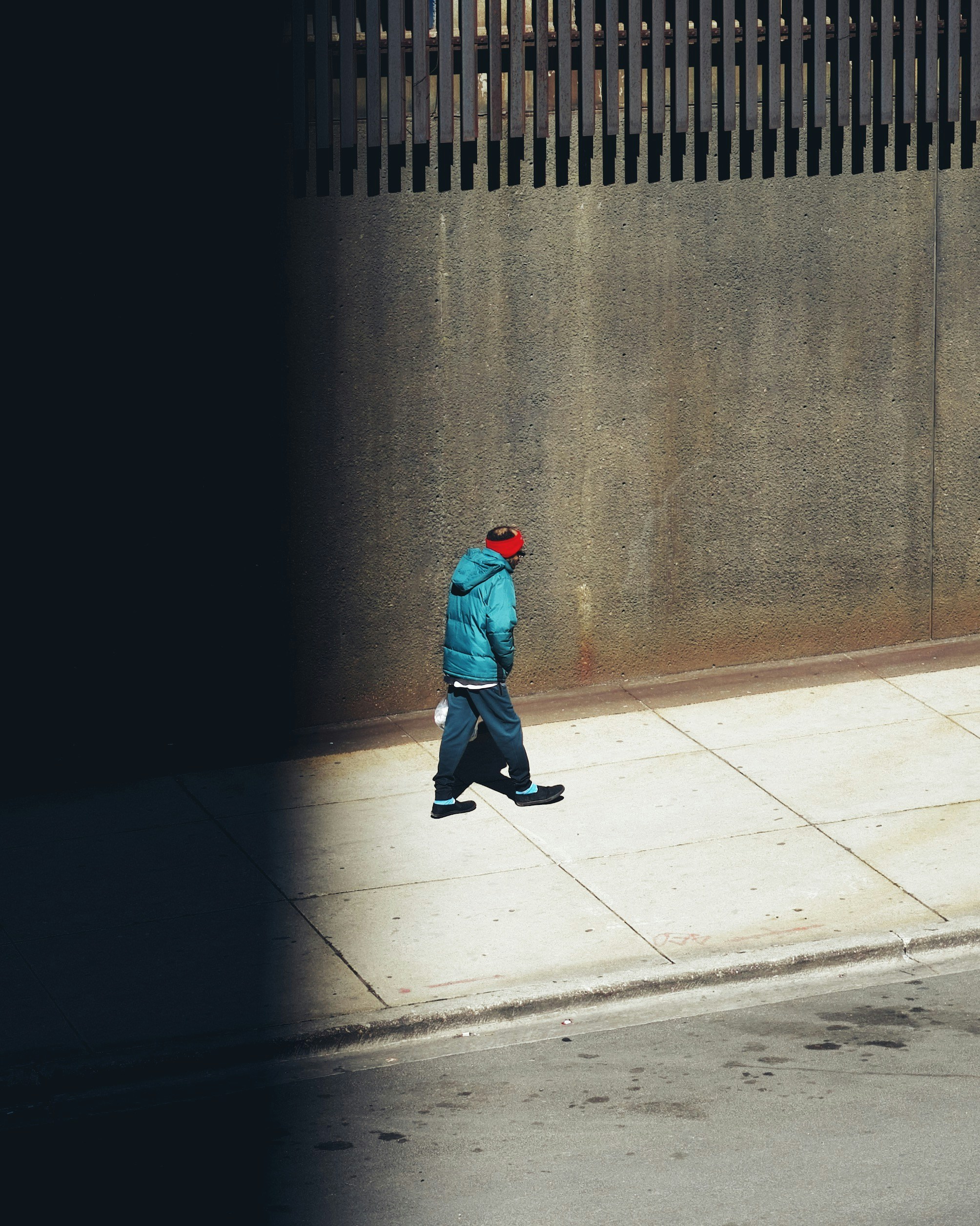 Turquoise in the Light: A Solitary Walk Along a Shadowed Wall