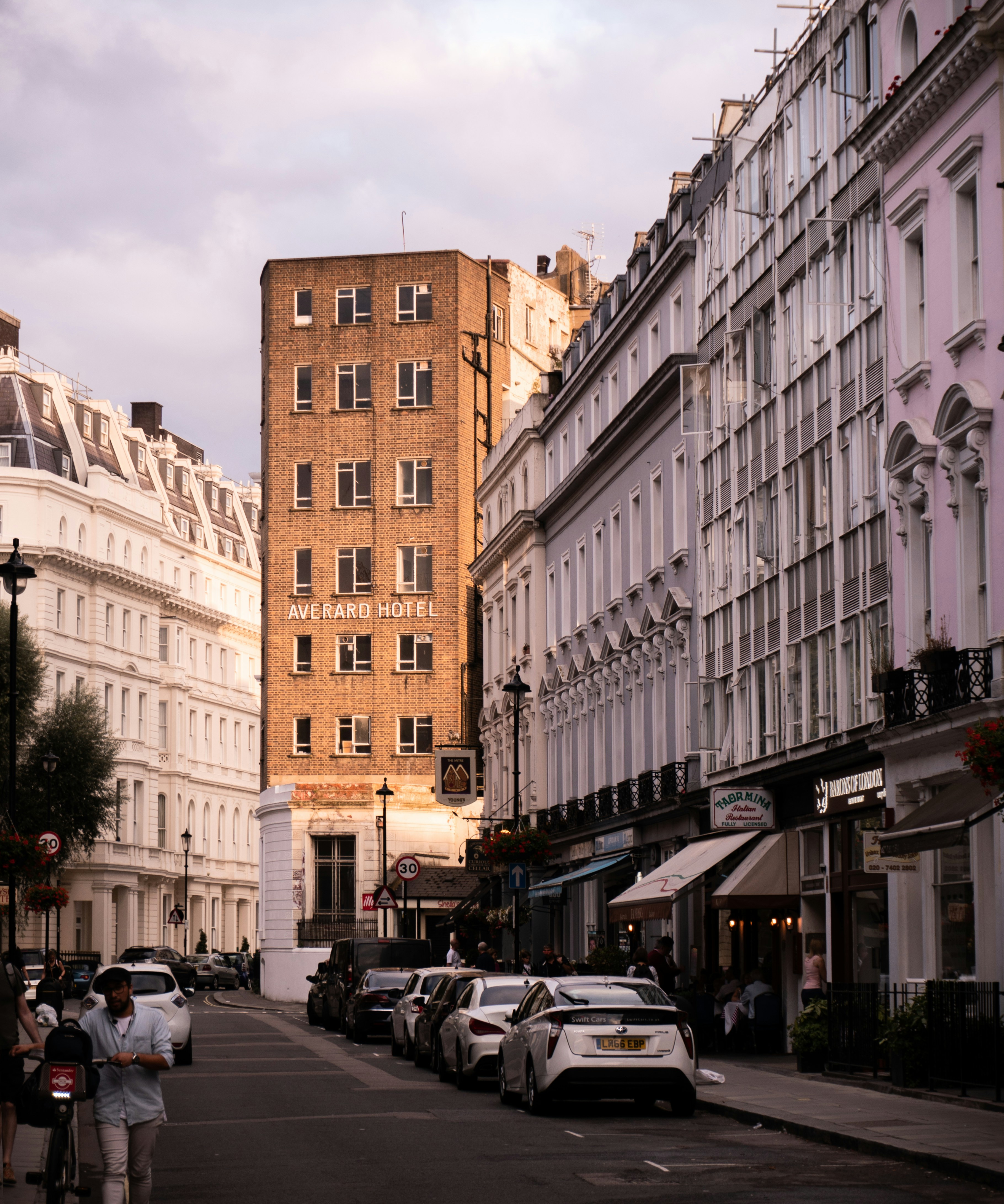 Cars parked on side of road near high rise buildings during daytime ...