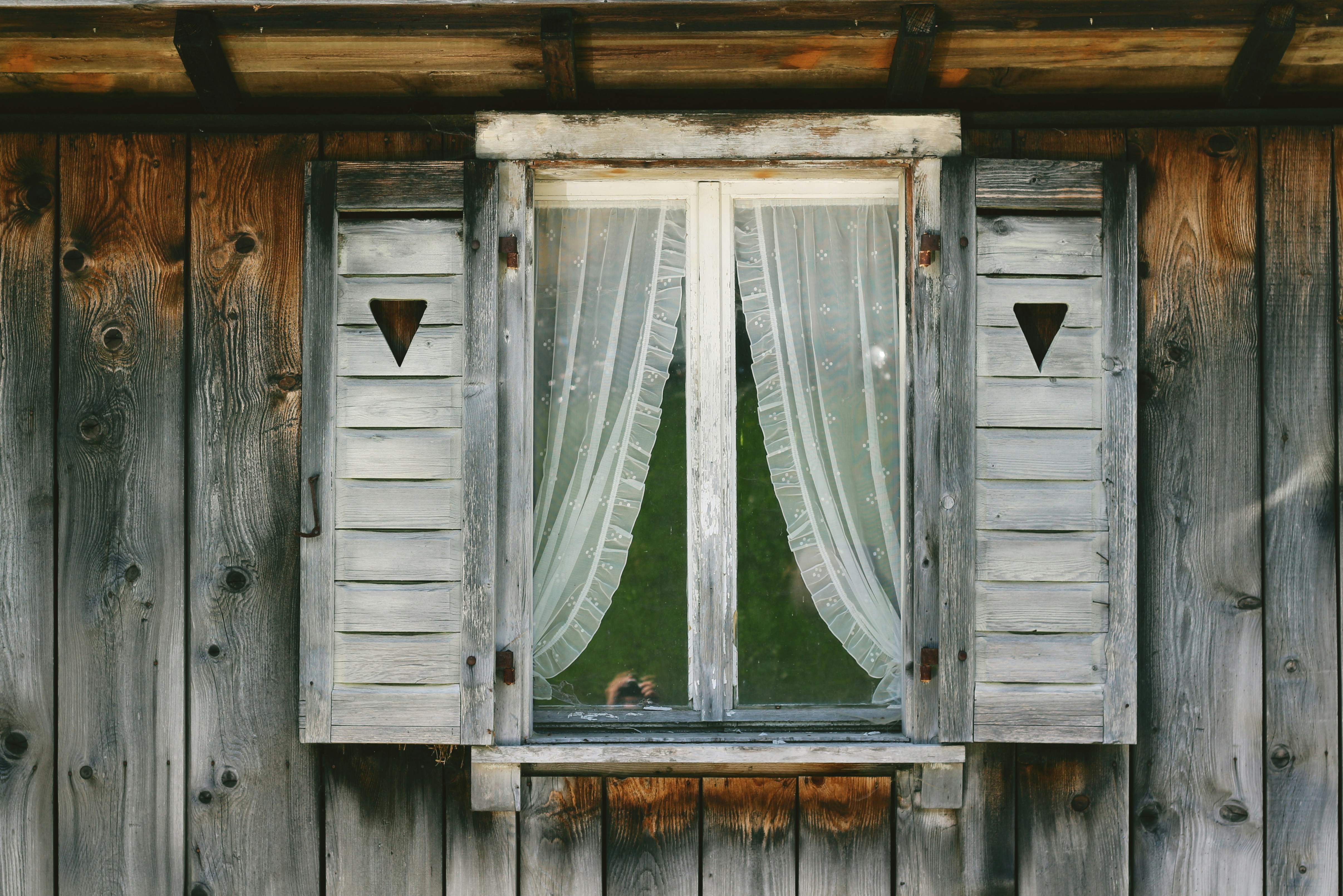 white wooden window frame with white window blindsTeo Zac