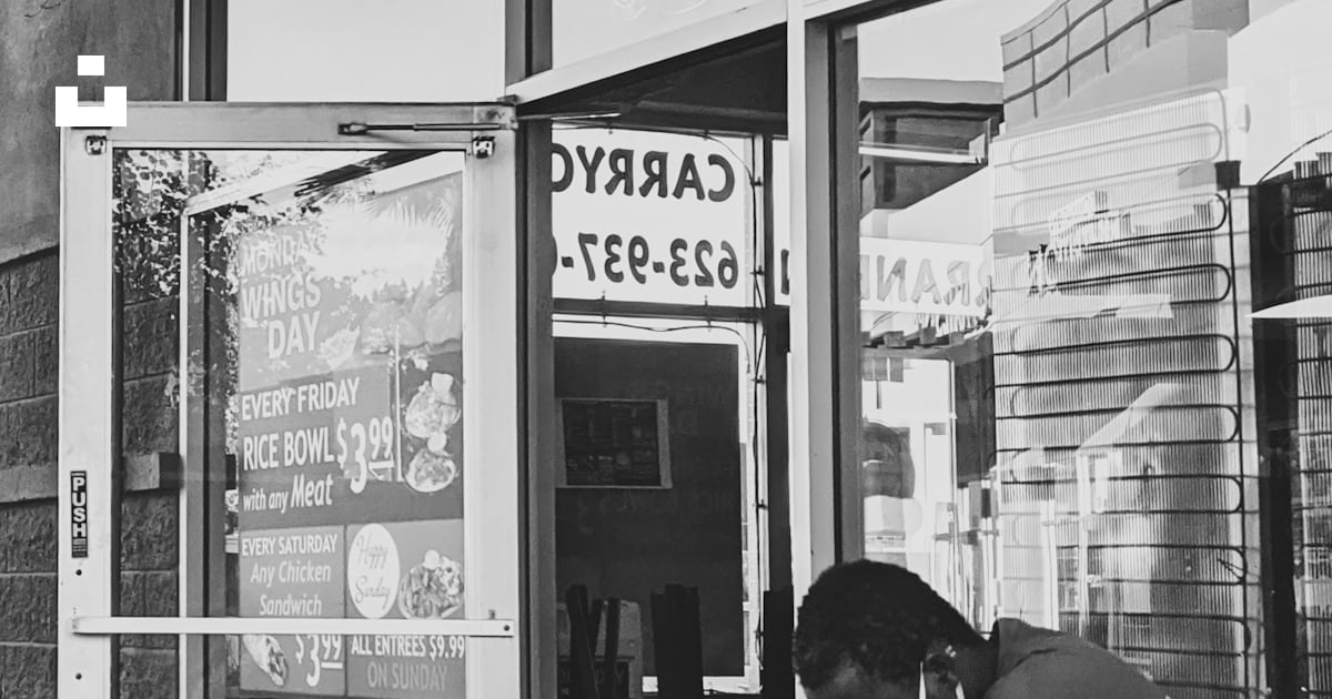 店の前の椅子に座っている黒いジャケットの男の写真 Unsplashの無料グレー写真
