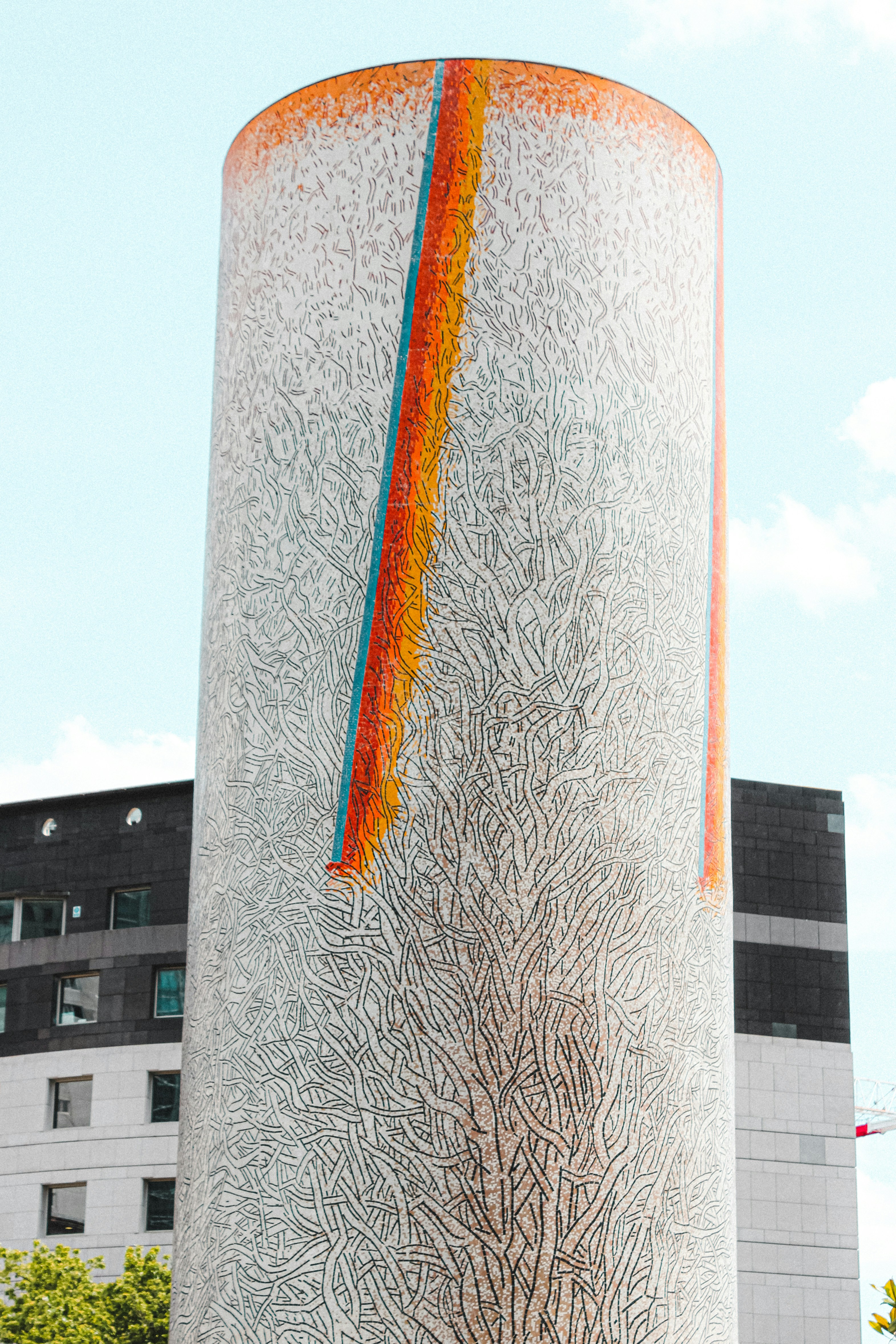 Veined Cylinder: A Neon Blue-Orange Stripe on Urban Metal