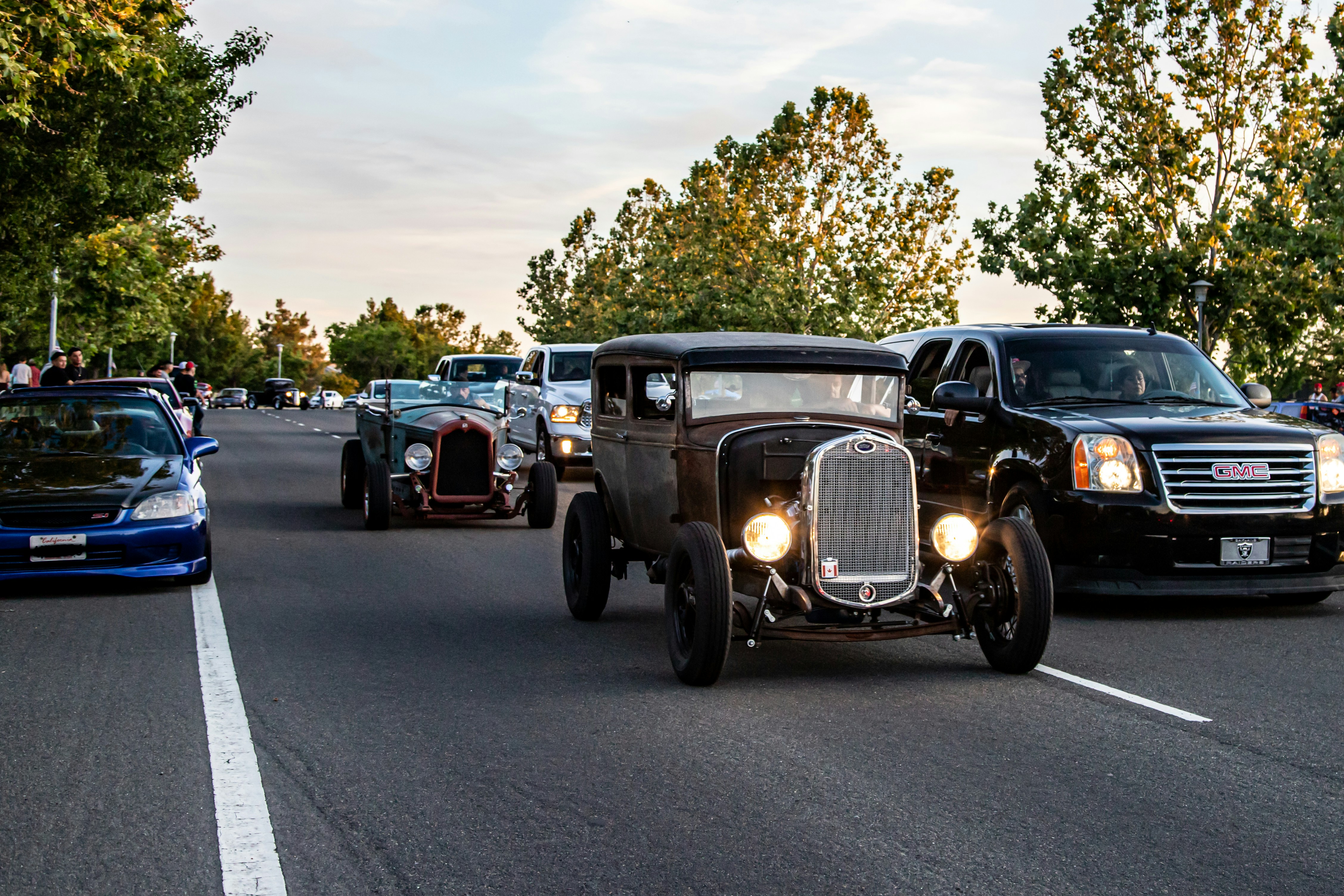 Vintage Vehicle Parade: A Pack of Classic Cars Rolling Down the Road
